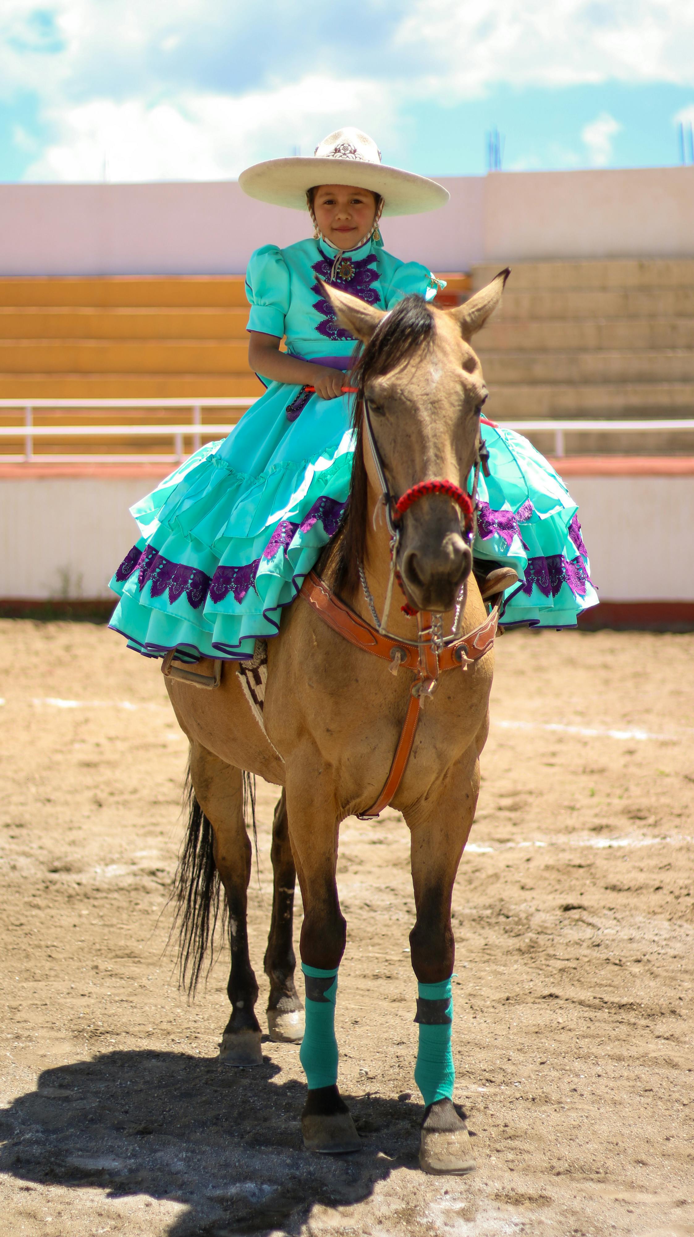 A girl in a blue dress riding a horse · Free Stock Photo