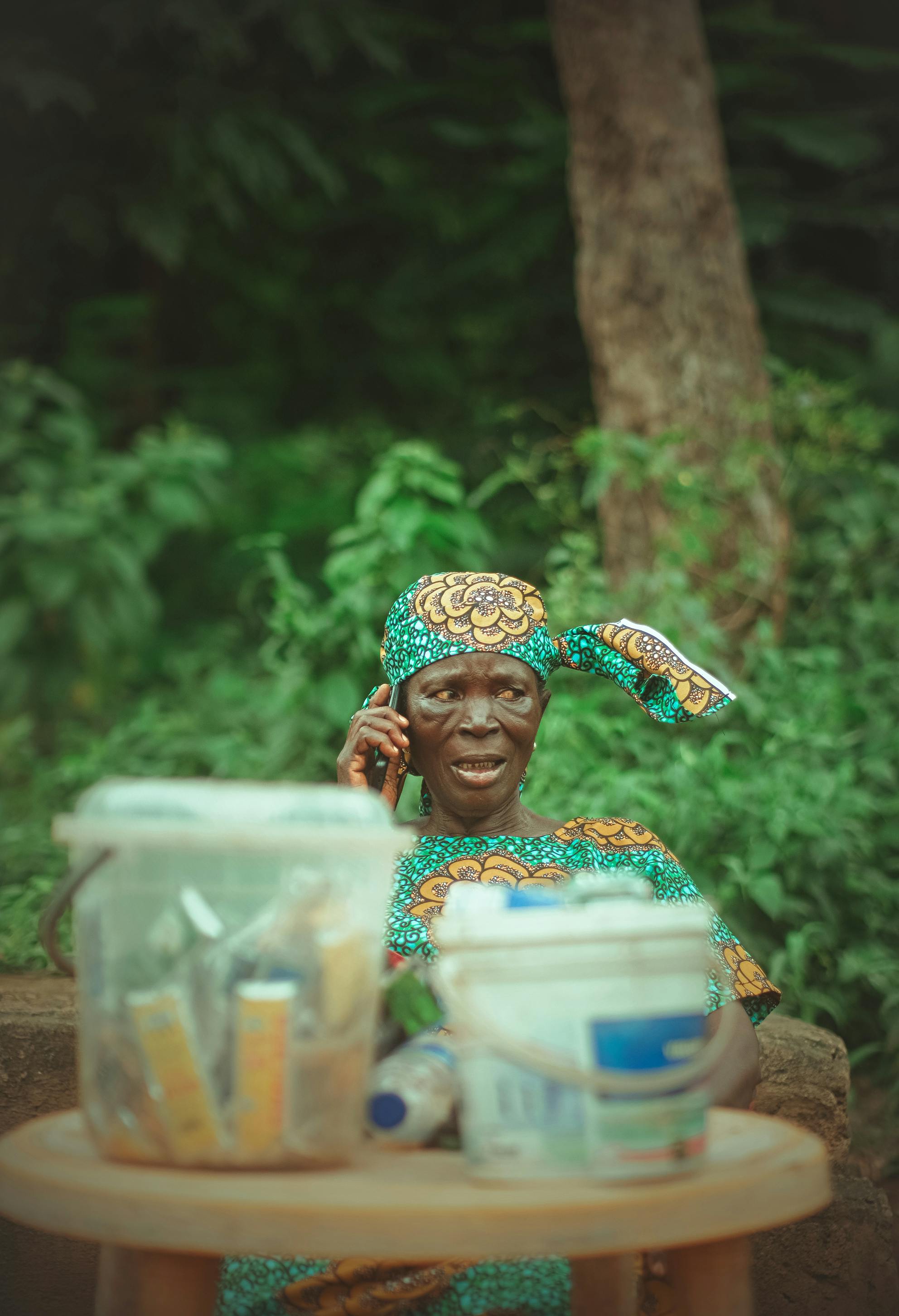 A woman sitting on a bench with a bucket of water · Free Stock Photo