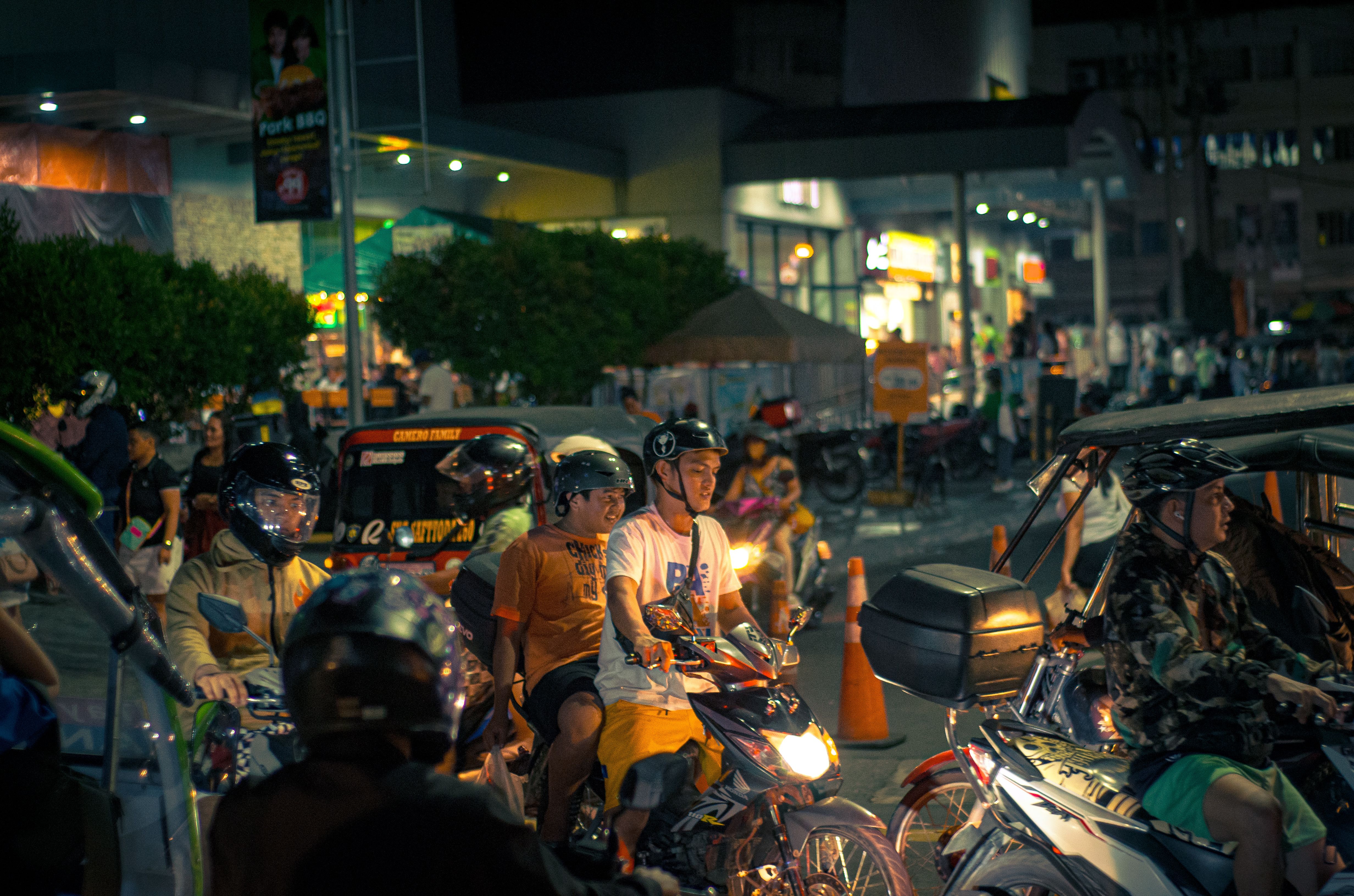 A group of people riding motorcycles down a street · Free Stock Photo