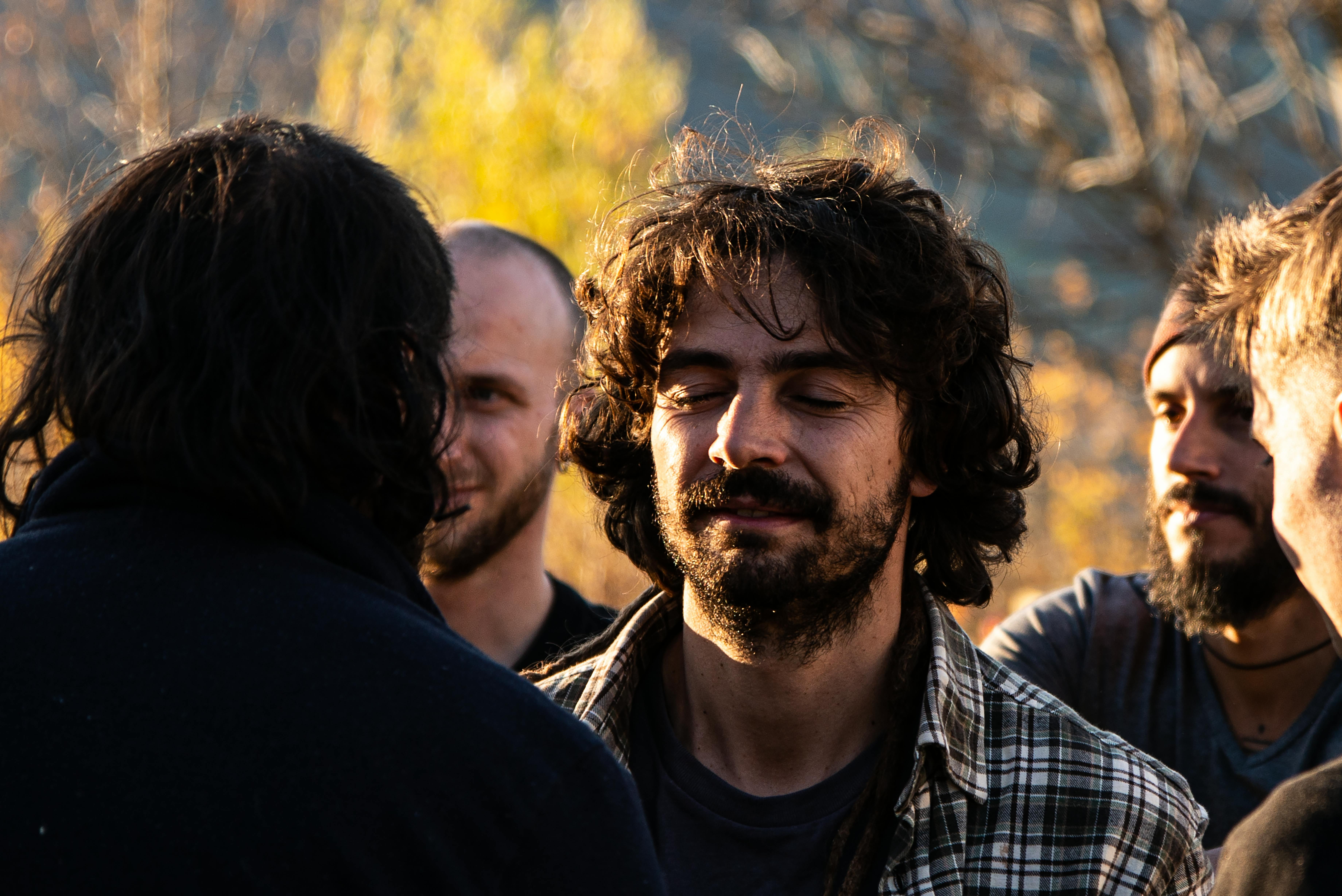 A group of men standing around talking · Free Stock Photo