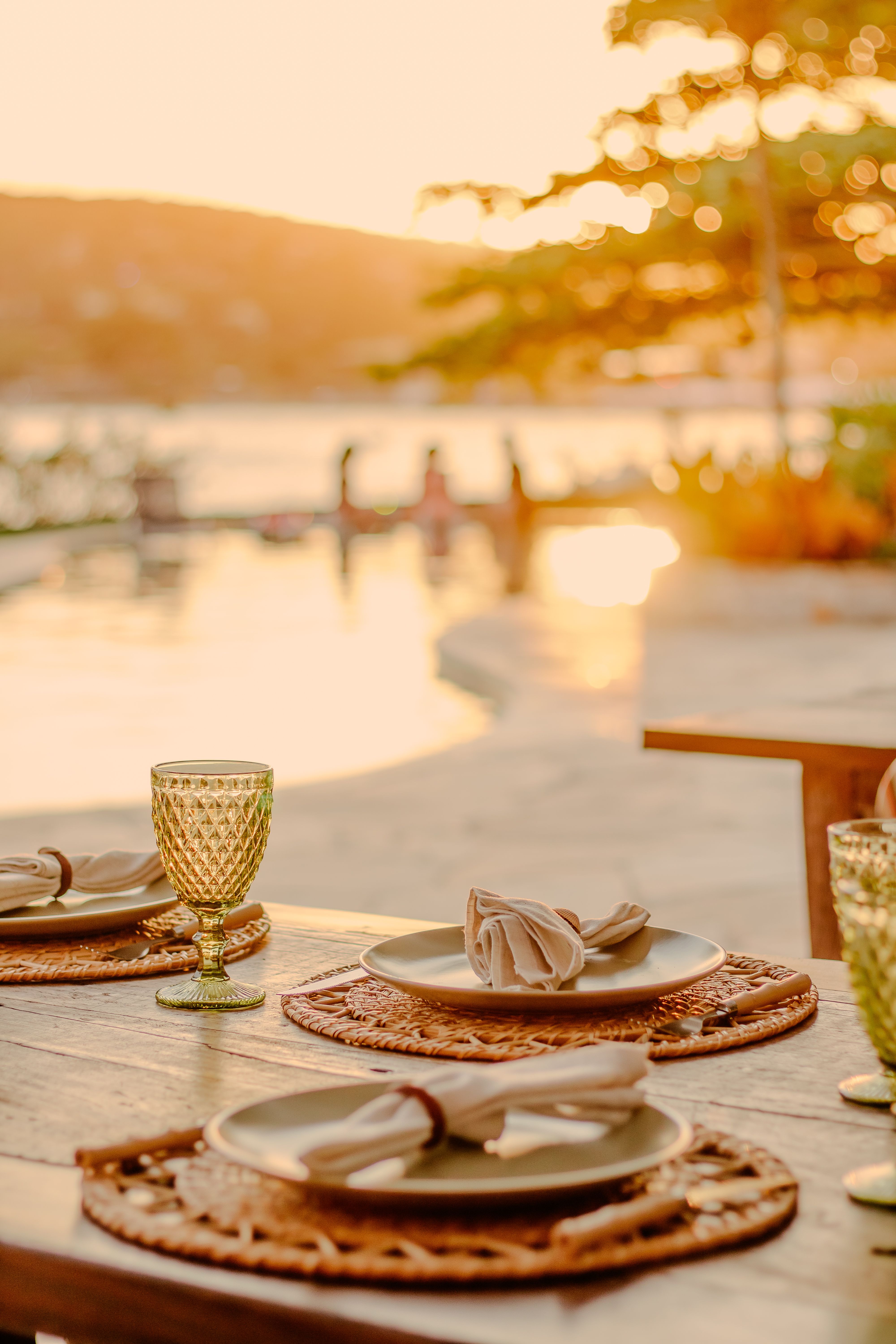 A table set for dinner with a view of the water · Free Stock Photo