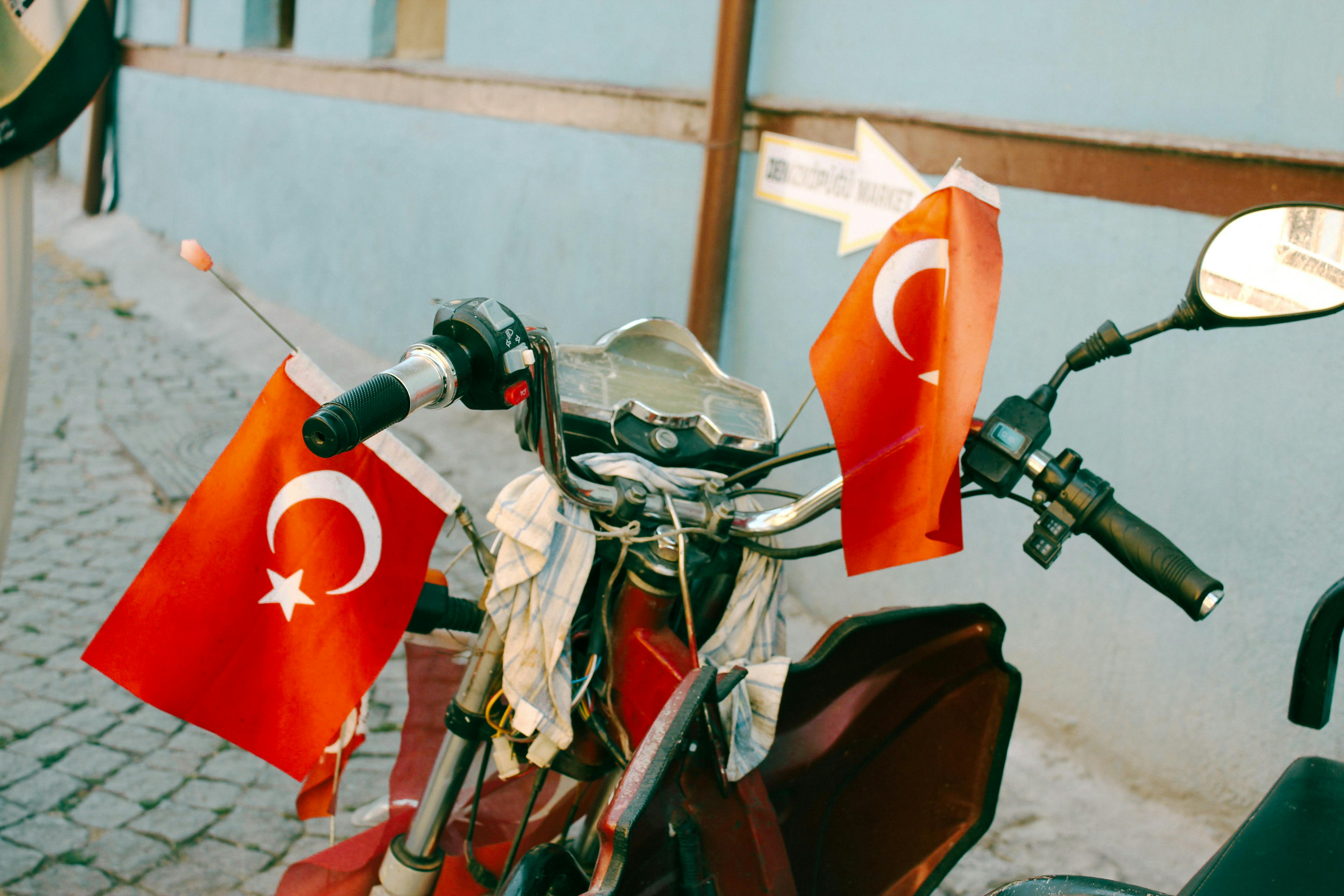 Motorbike with Turkish Flags on Cobblestone Street · Free Stock Photo