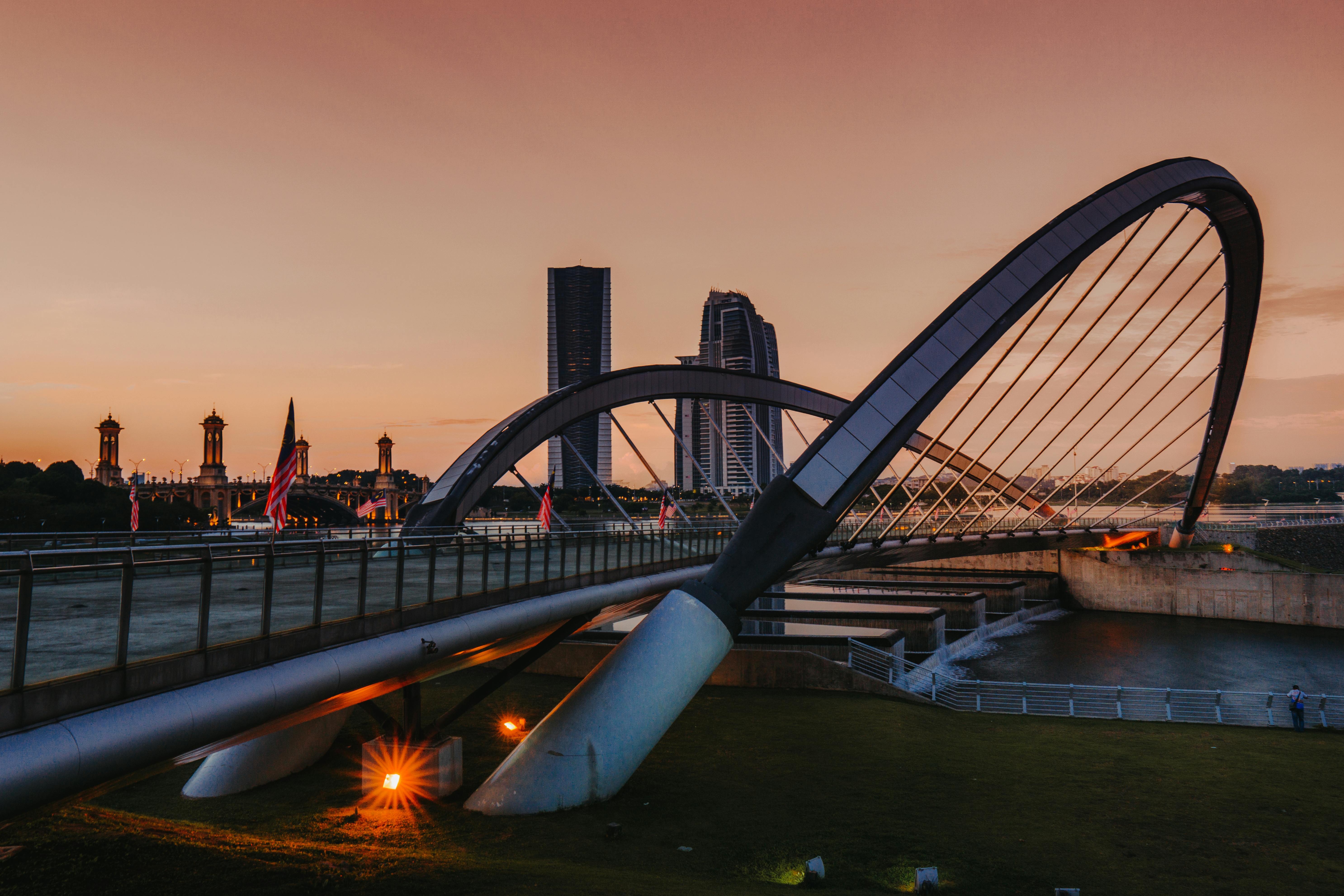 Silhouette of High Rise Buildings Beside Body of Water during Golden ...