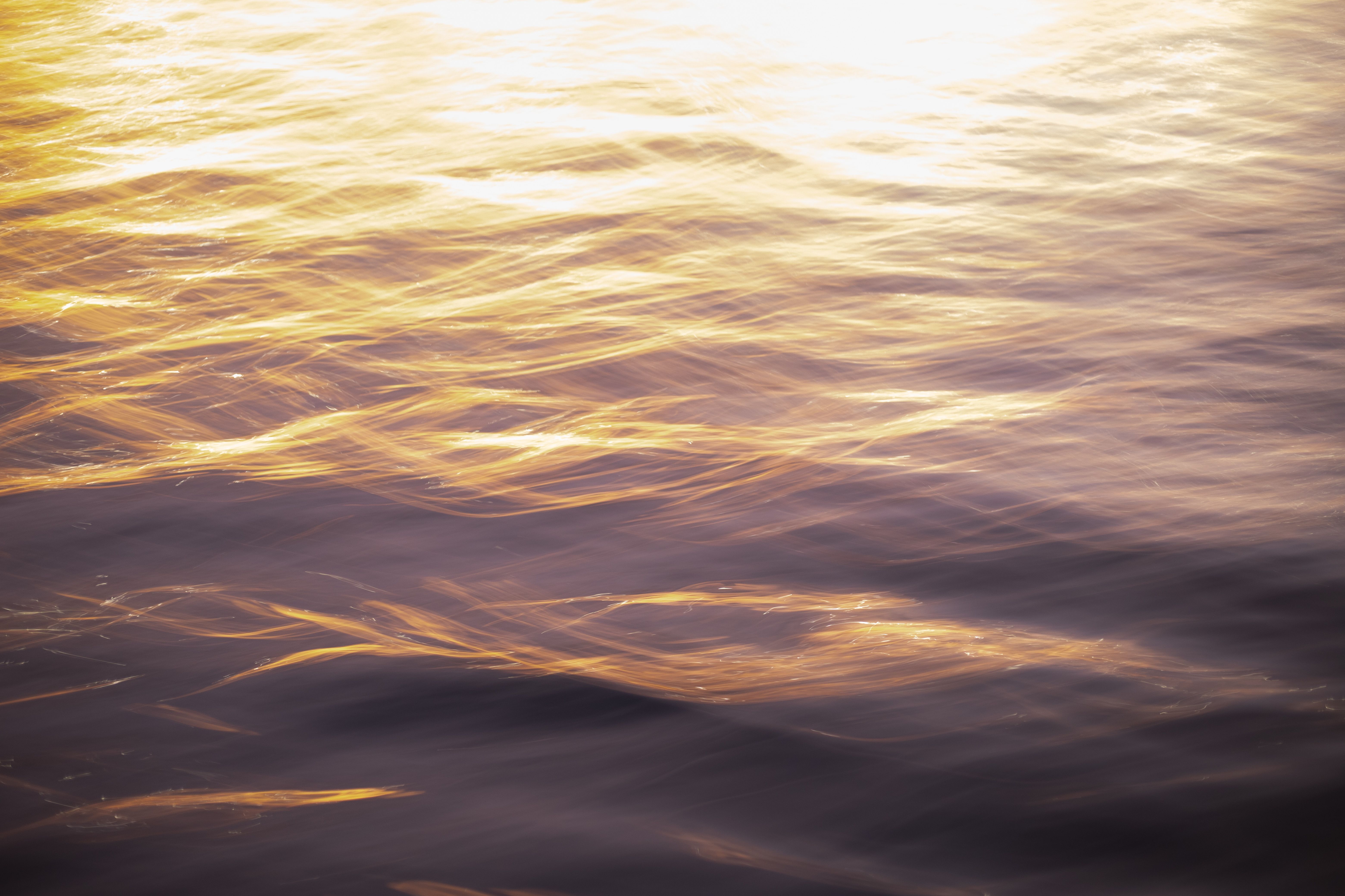 A sunset over the ocean with water and waves · Free Stock Photo