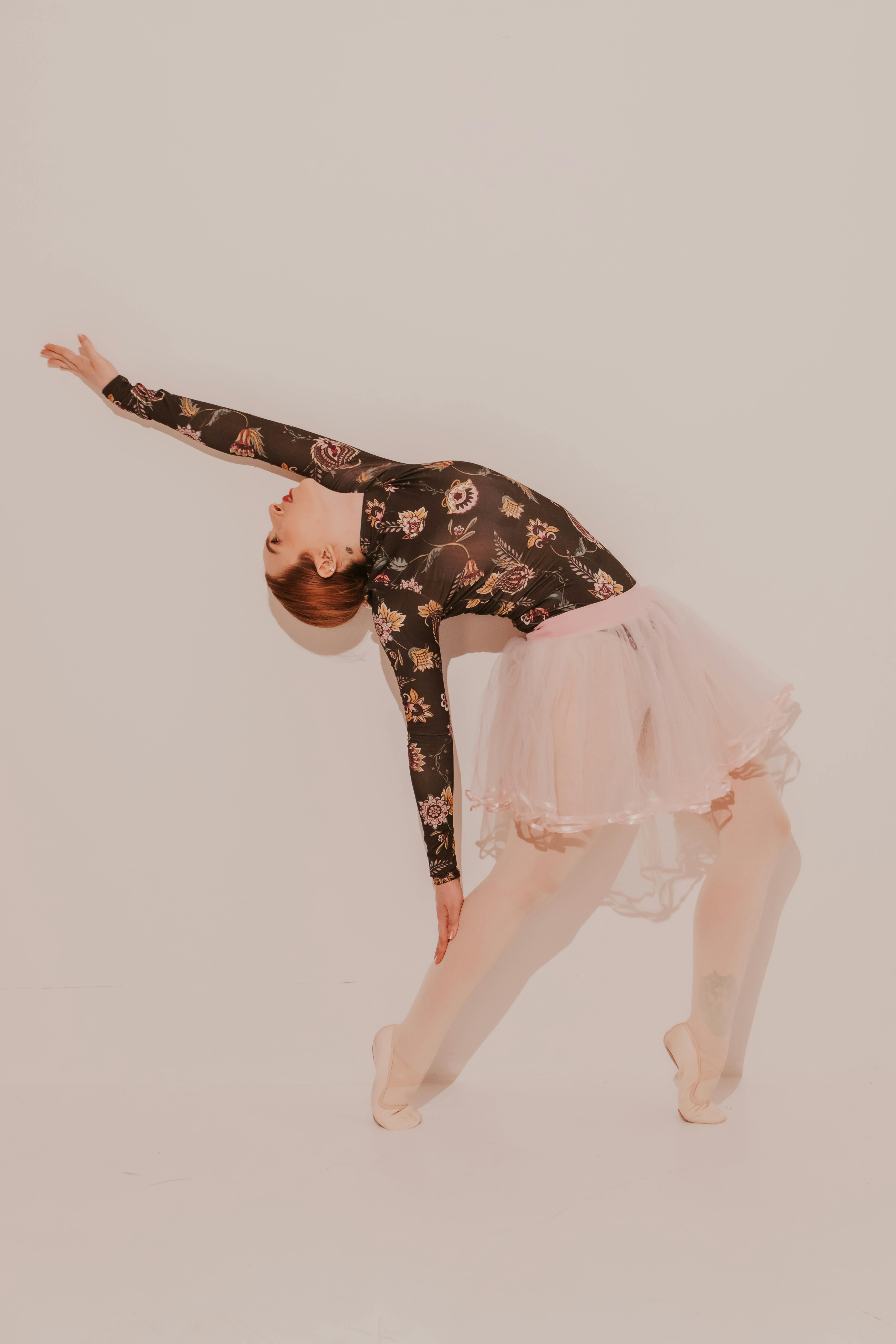 A young woman in a tutu is bending her arm · Free Stock Photo