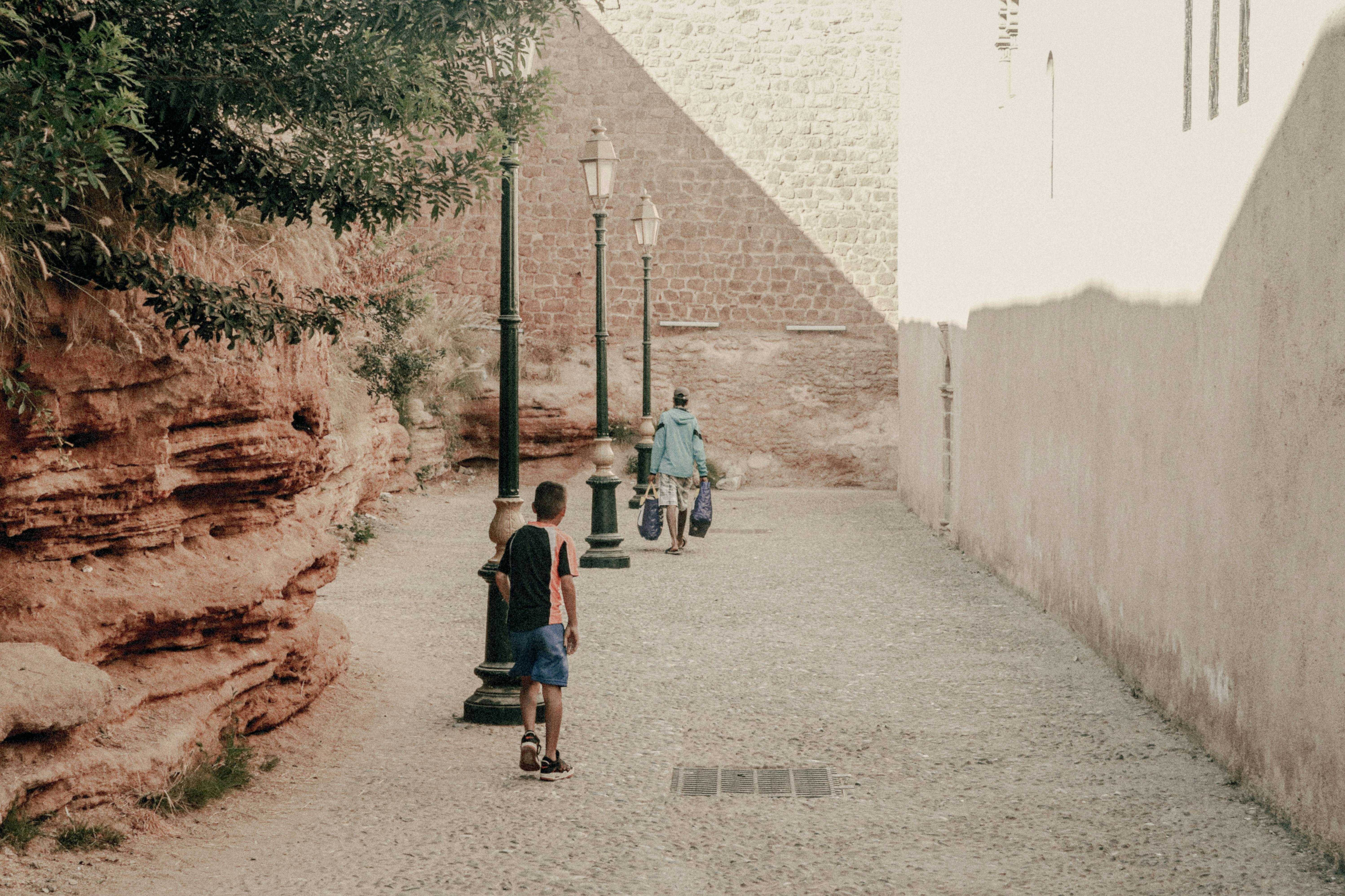 Two people walking down a narrow alleyway with a sign that says, 'the ...