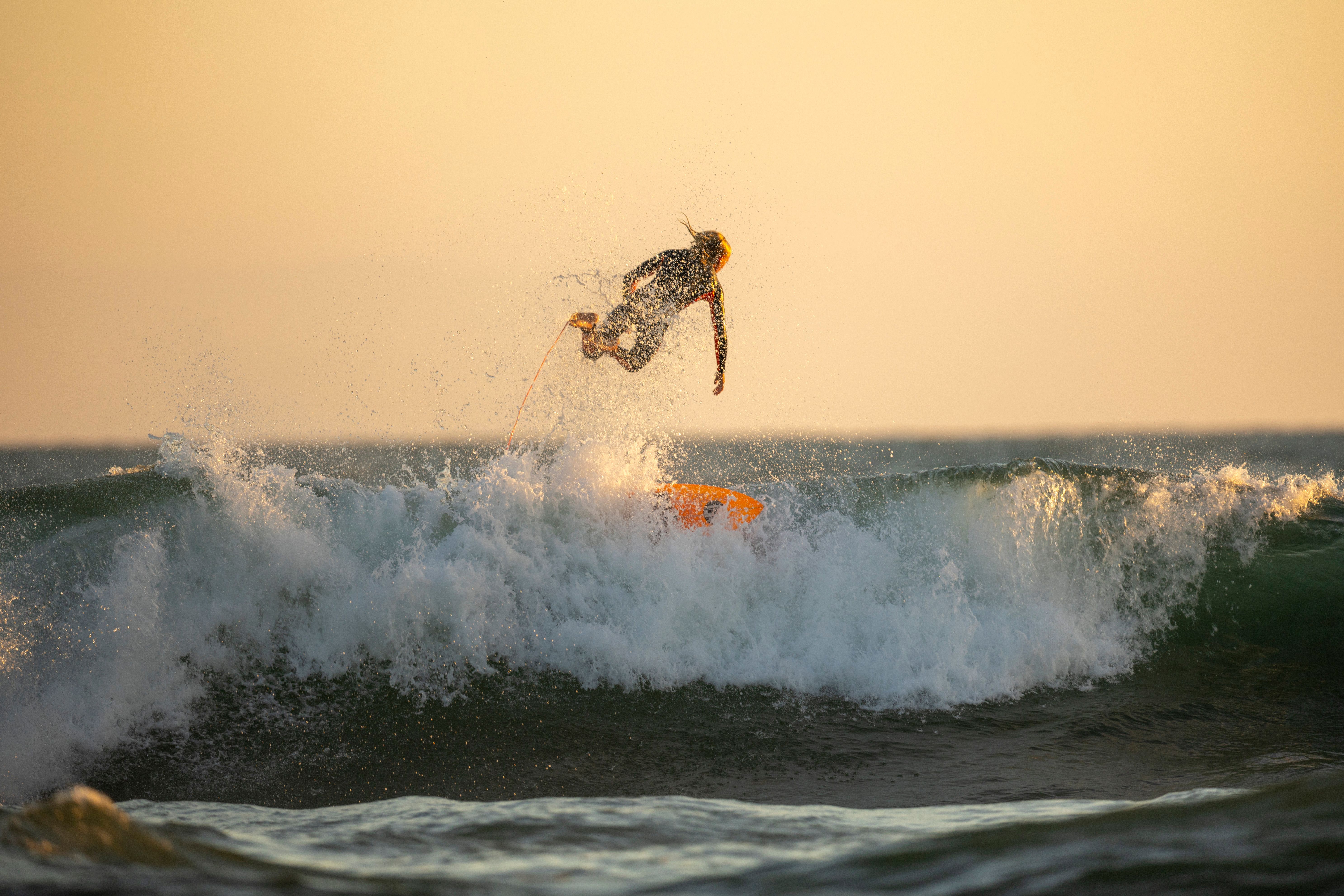 A surfer is jumping off of a wave · Free Stock Photo