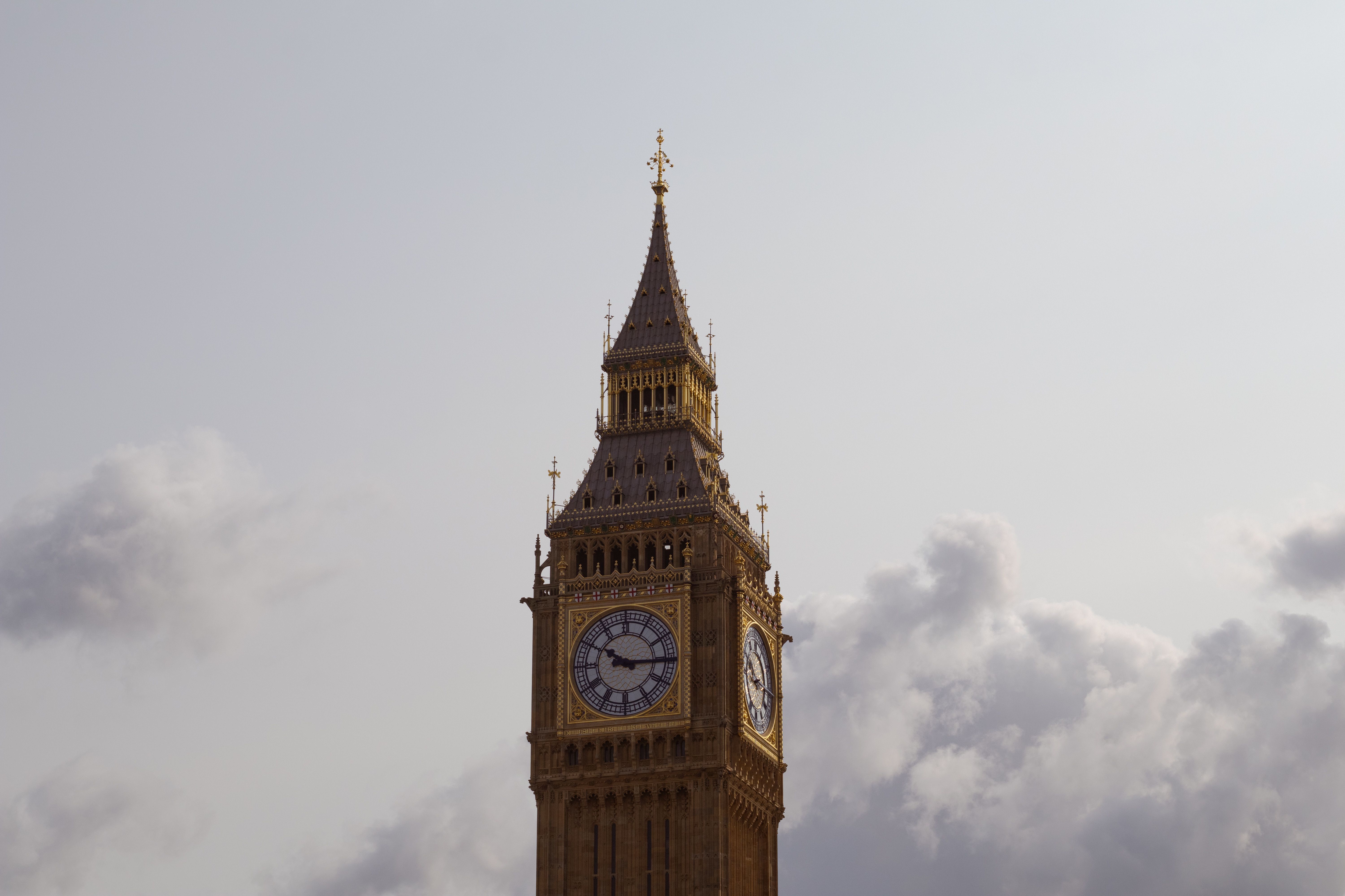 A clock tower with a big ben in the background · Free Stock Photo