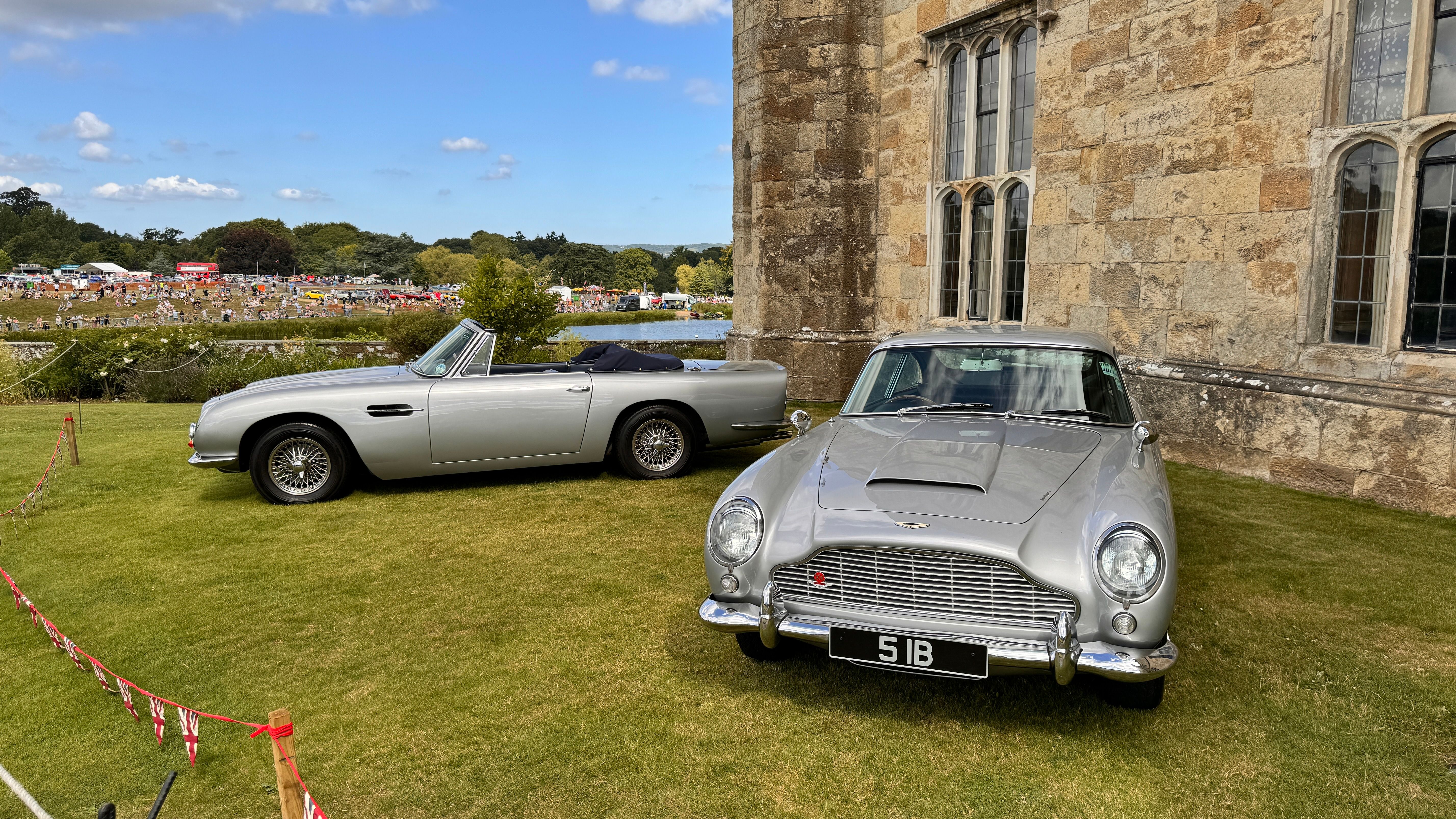 Two classic cars parked in front of a castle · Free Stock Photo