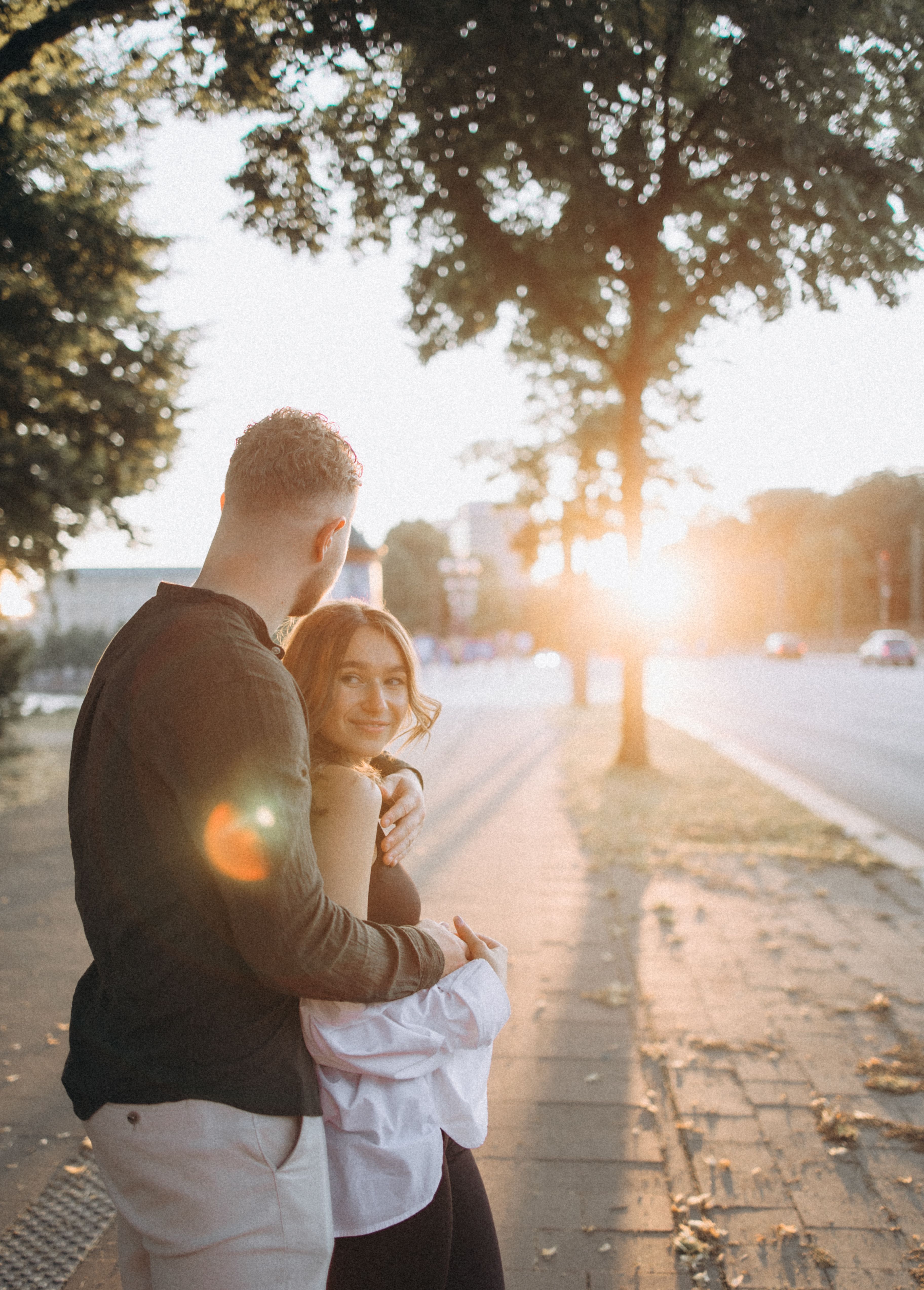 A couple embracing in the sun on a street · Free Stock Photo