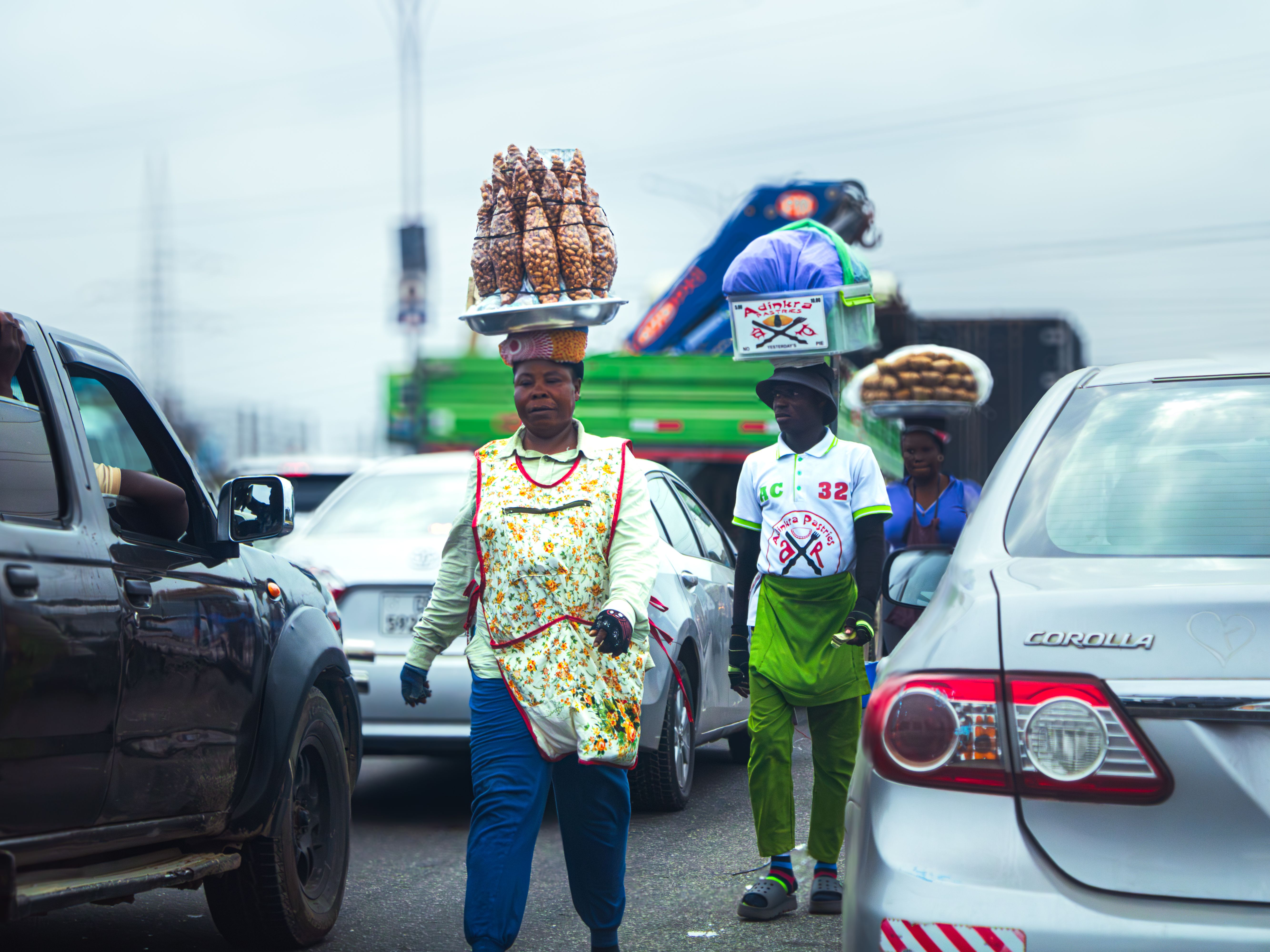 A woman carrying a basket of food on her head · Free Stock Photo