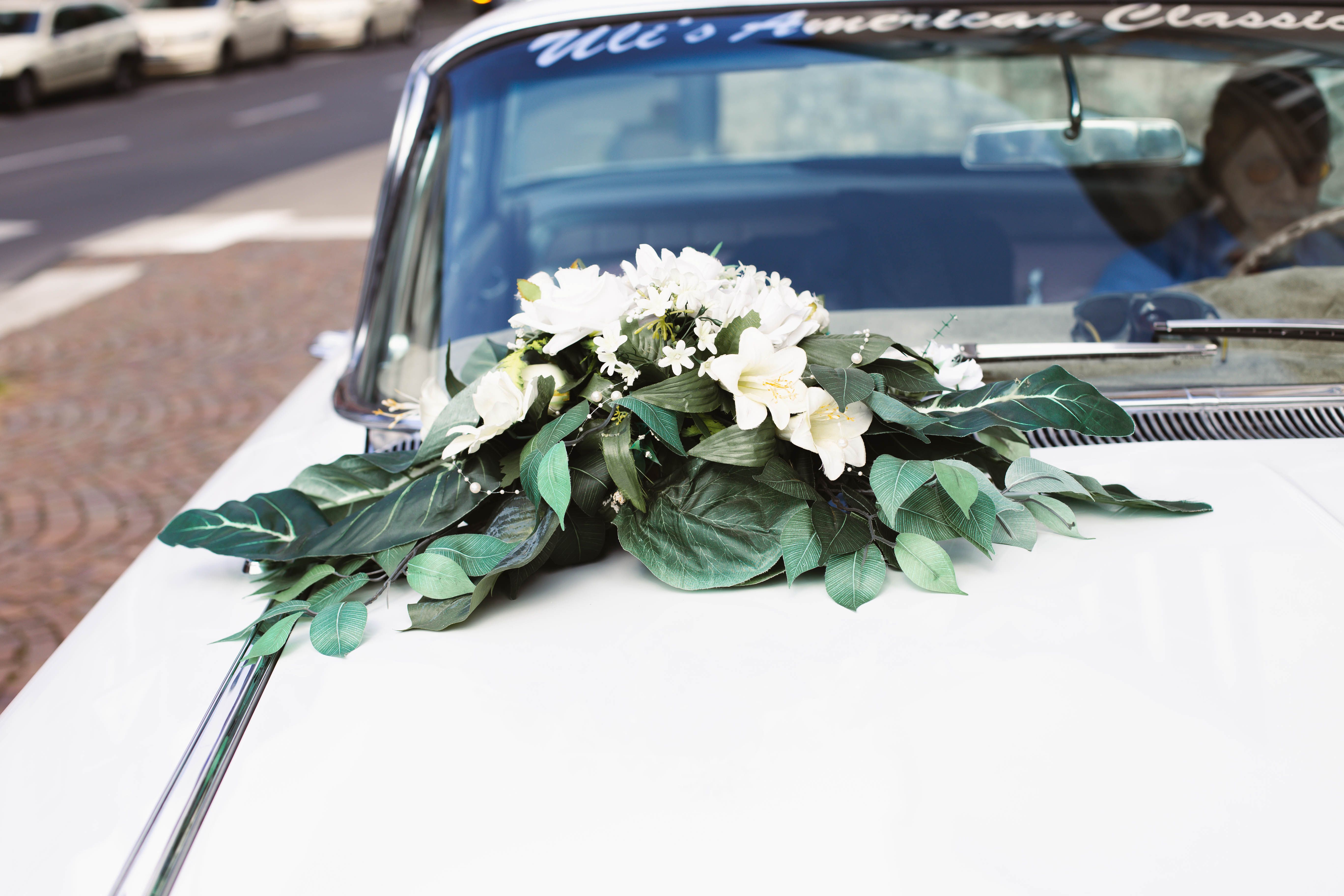 A white car with flowers on the hood · Free Stock Photo