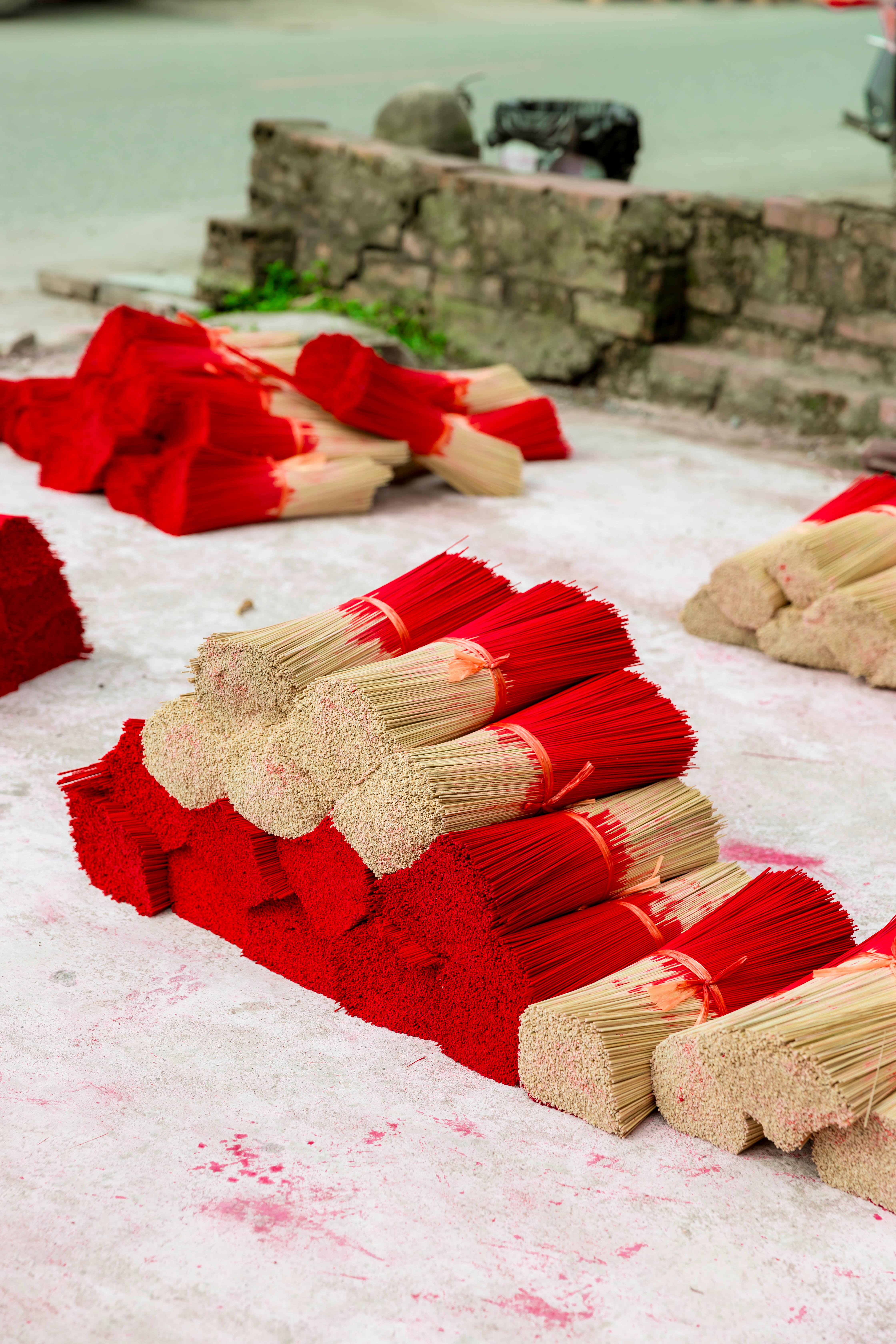 Red and white sticks are piled up on the ground · Free Stock Photo