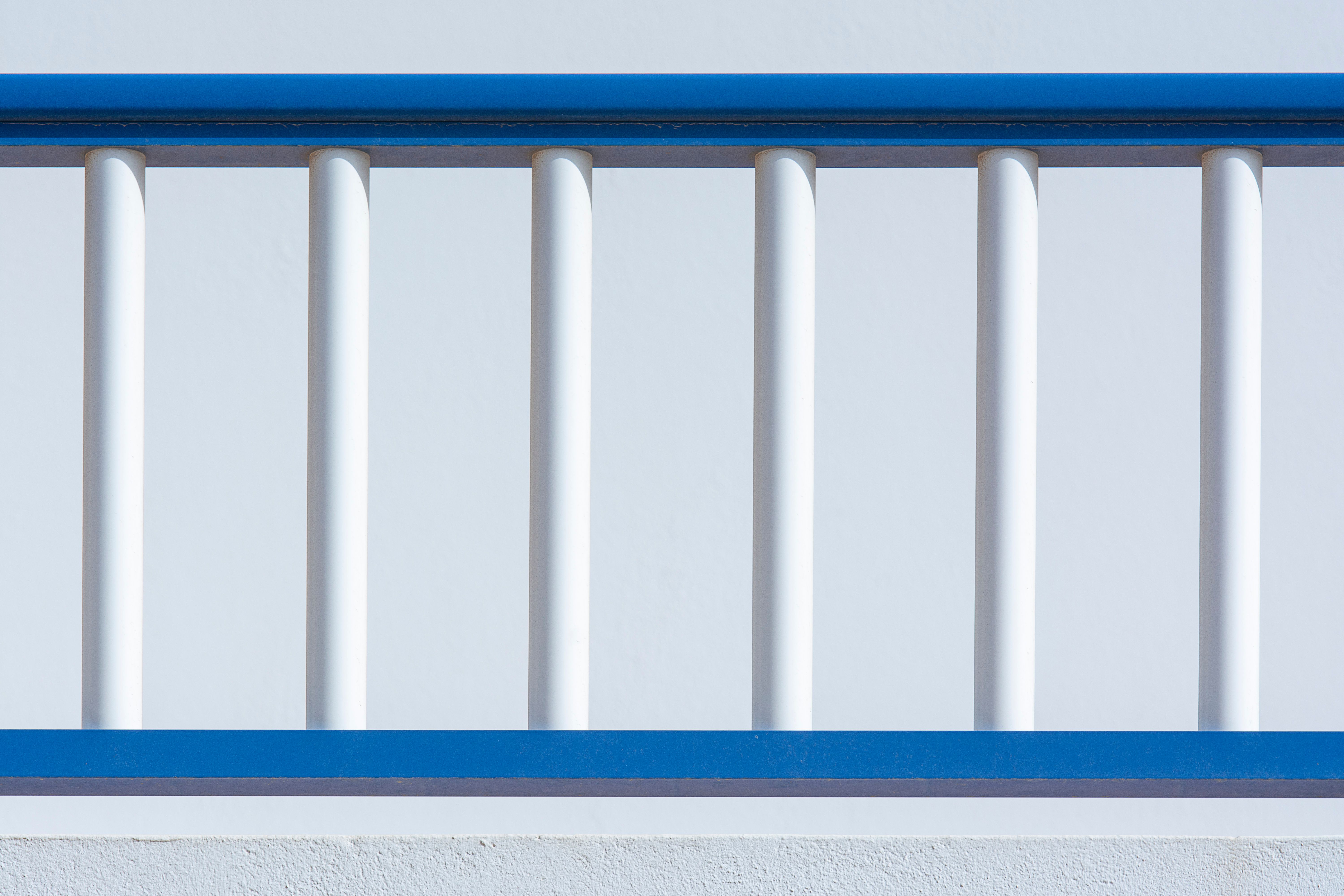 A white and blue railing with a blue bar · Free Stock Photo