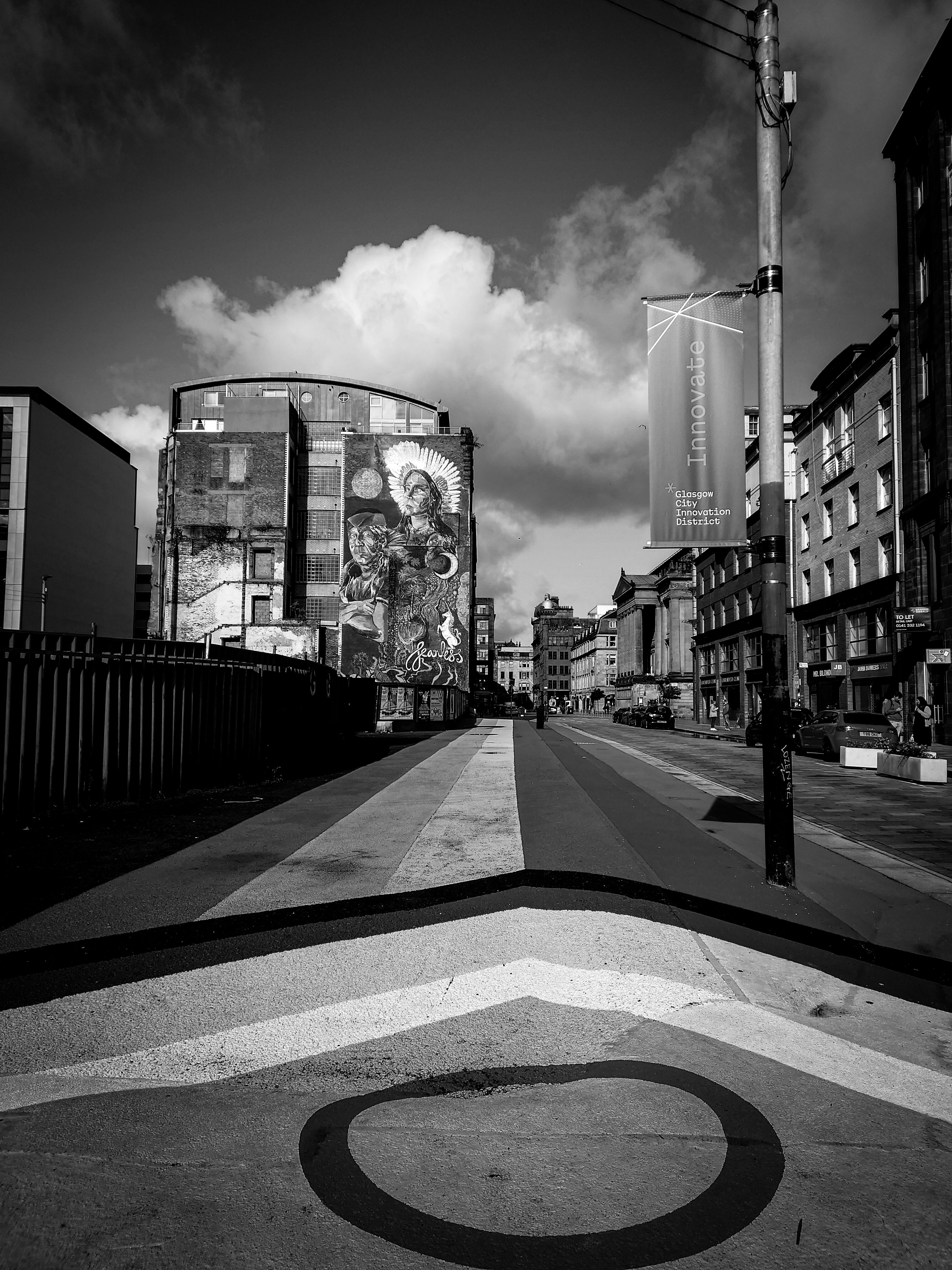 A black and white photo of a street with a circle in the middle · Free ...