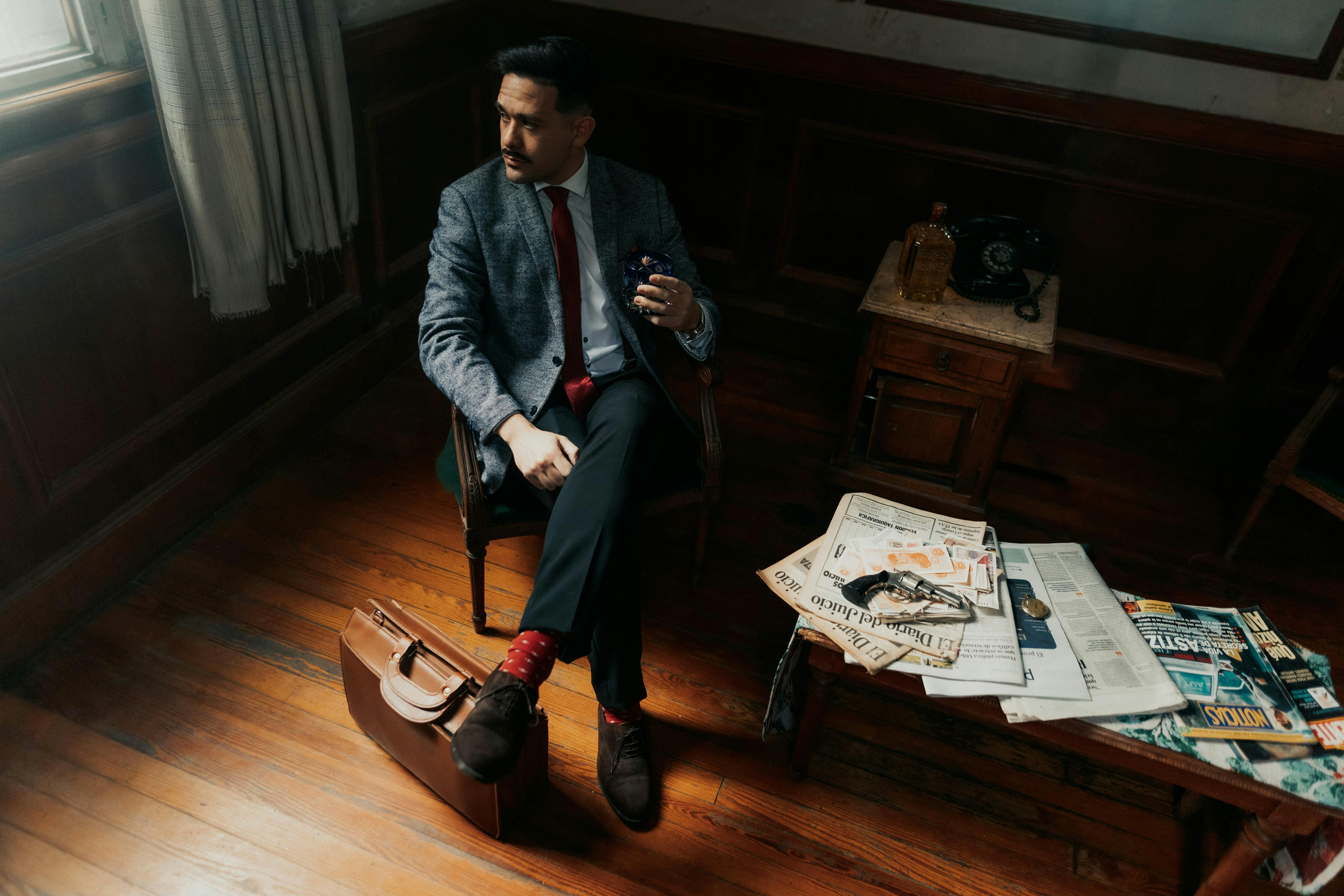 A man sitting on a chair with a newspaper · Free Stock Photo