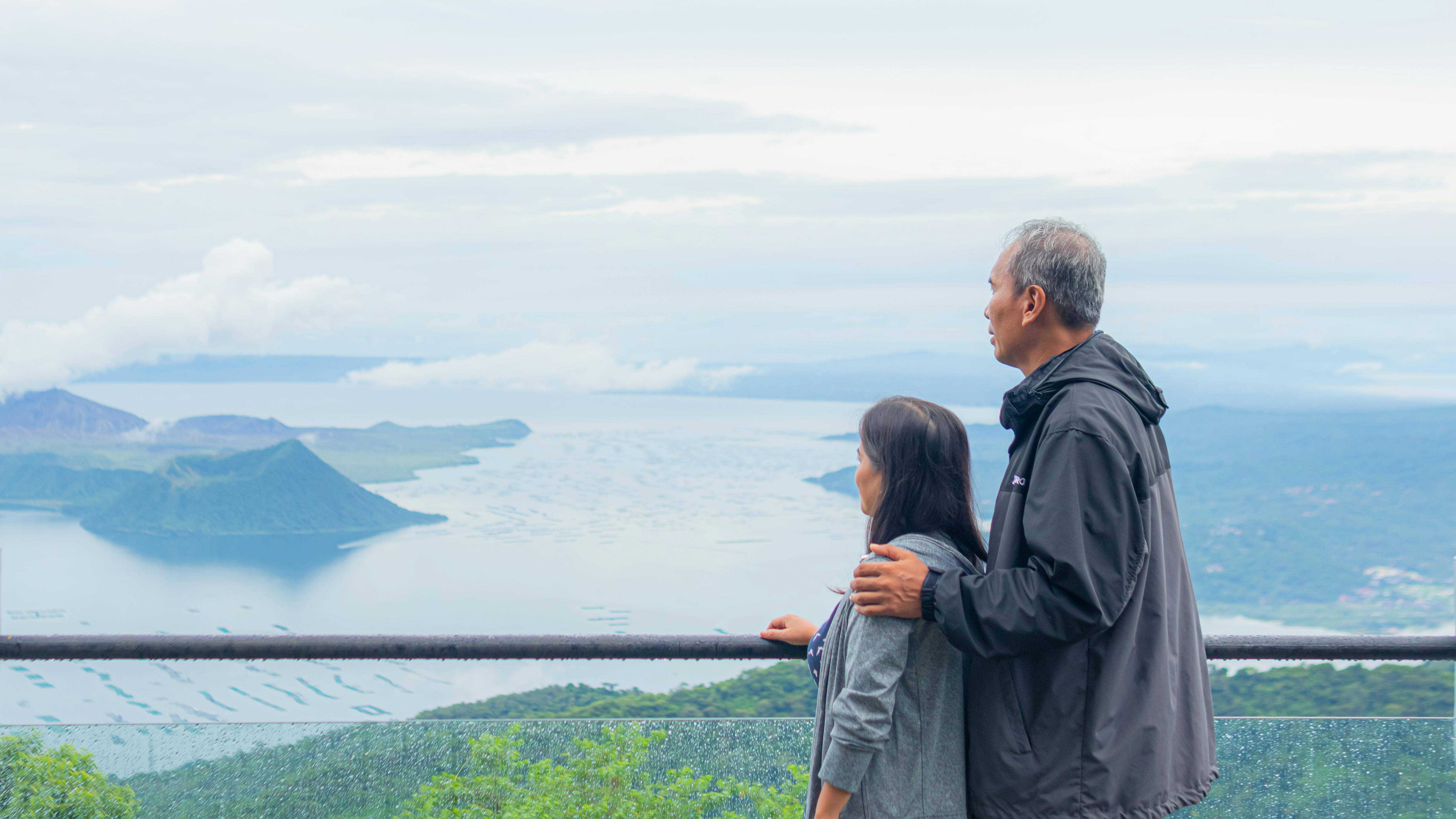 A man and woman looking out over the ocean from a lookout · Free Stock ...
