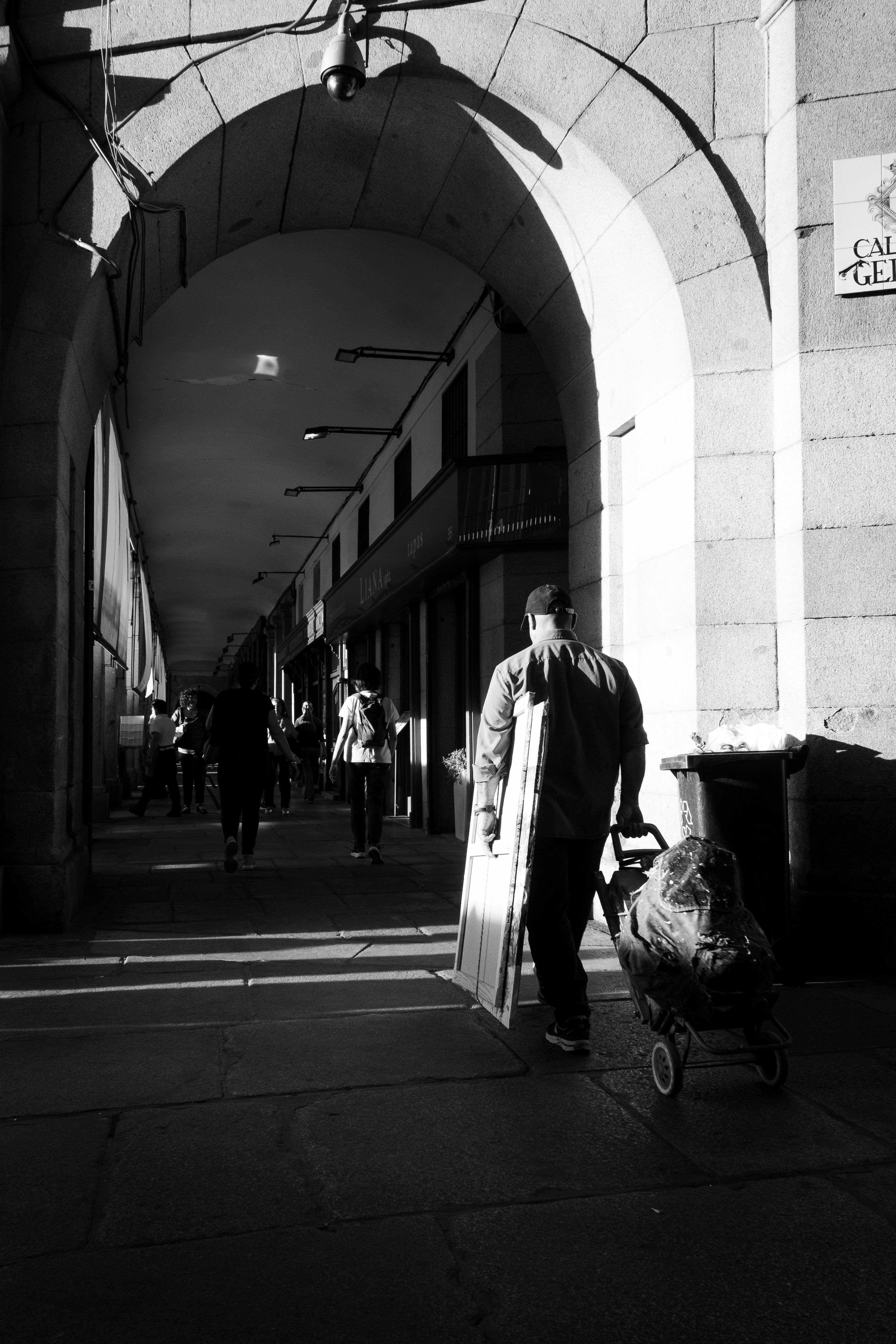 A man walking down a street with a suitcase · Free Stock Photo
