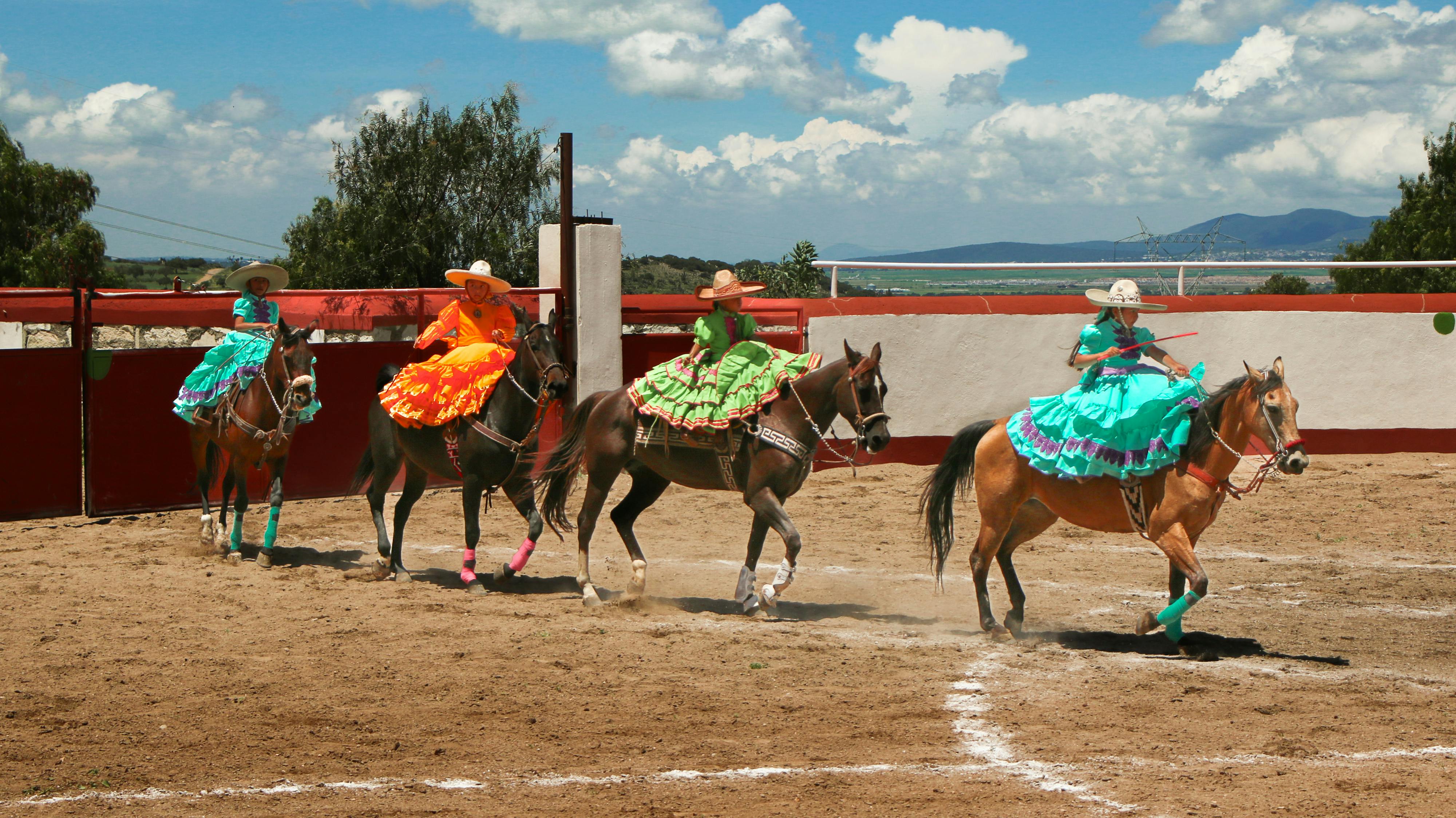 A group of women riding horses in colorful dresses · Free Stock Photo