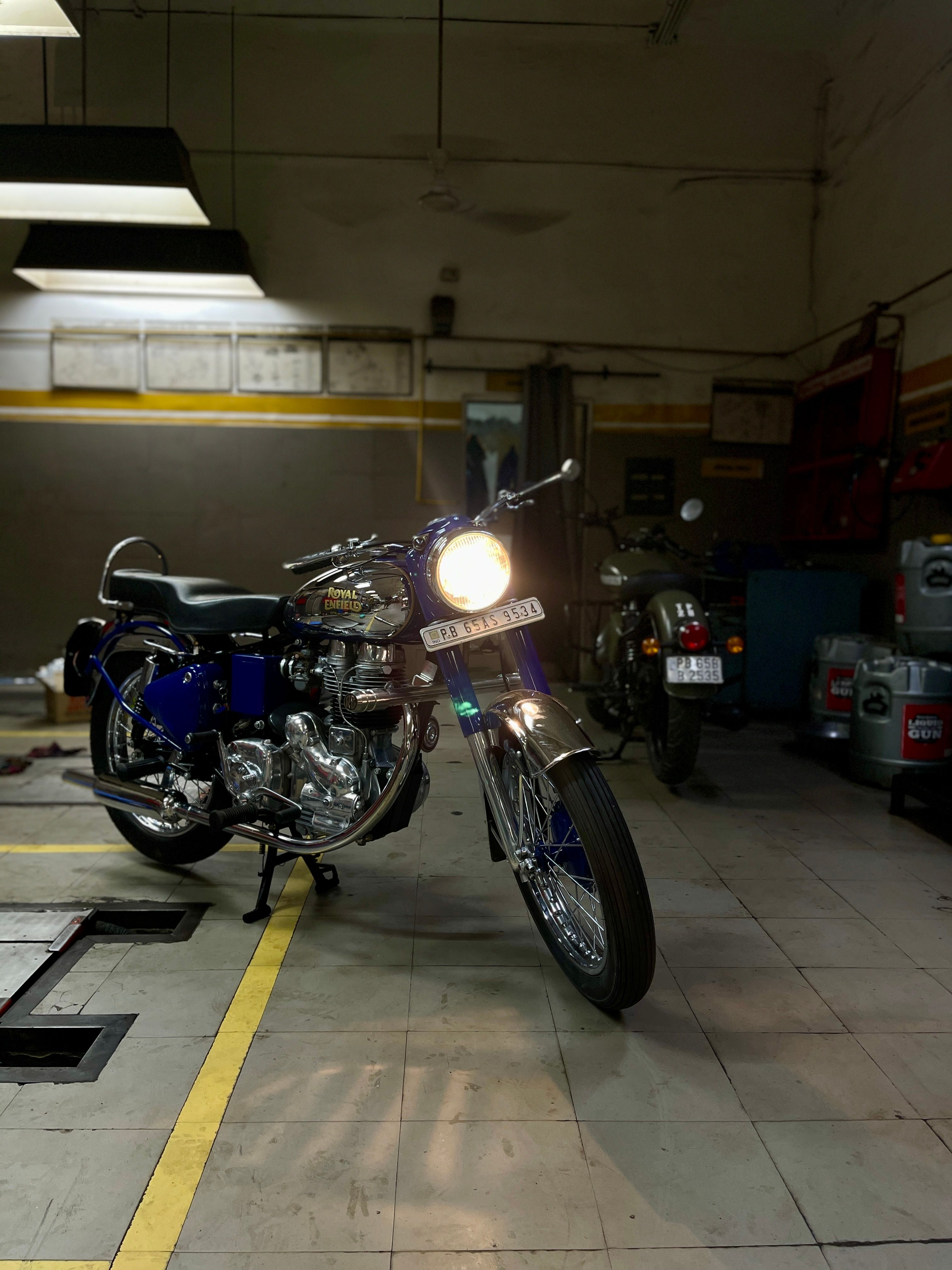 A blue and silver motorcycle is parked in a garage · Free Stock Photo
