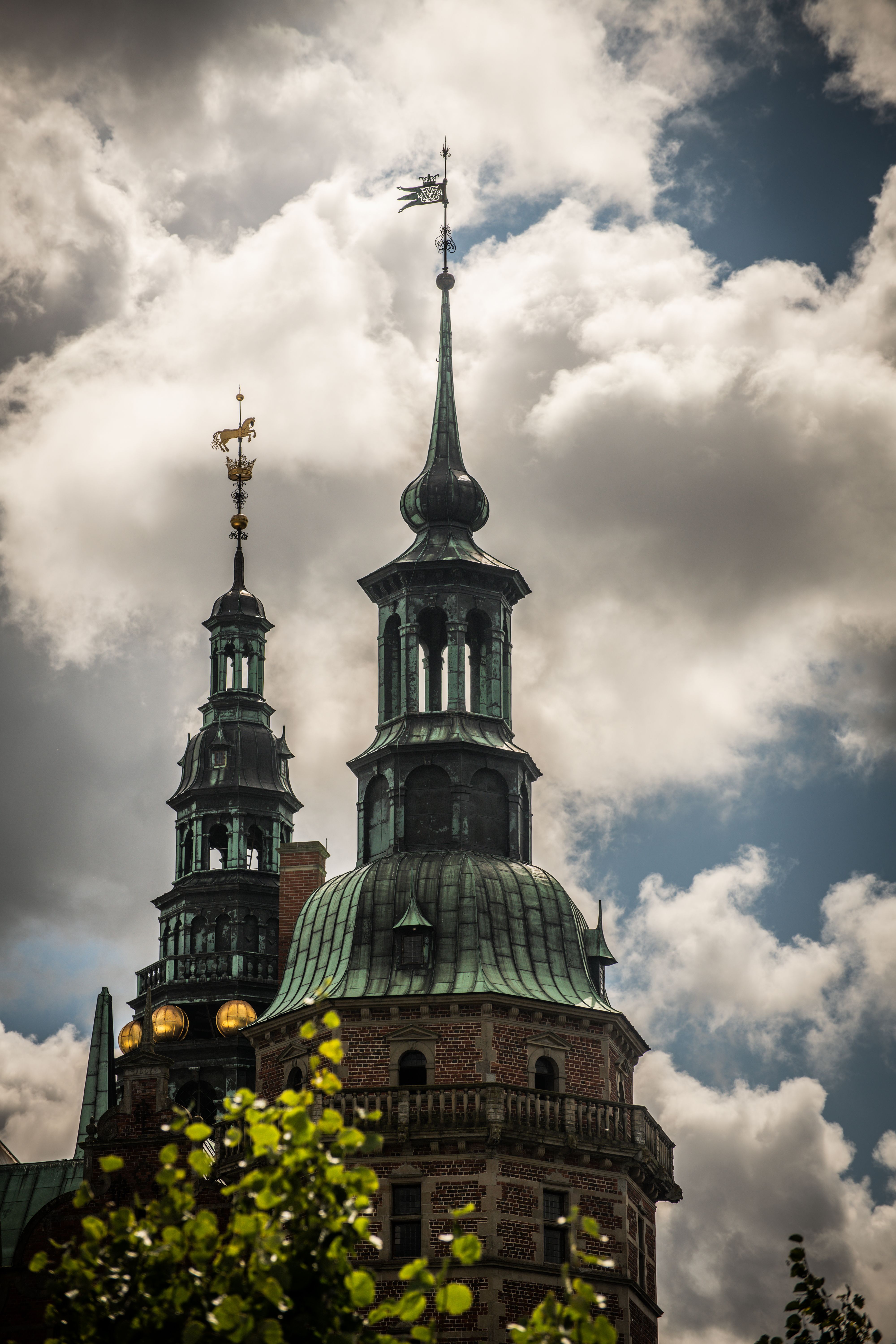 A view of two tall spires with clouds in the sky · Free Stock Photo
