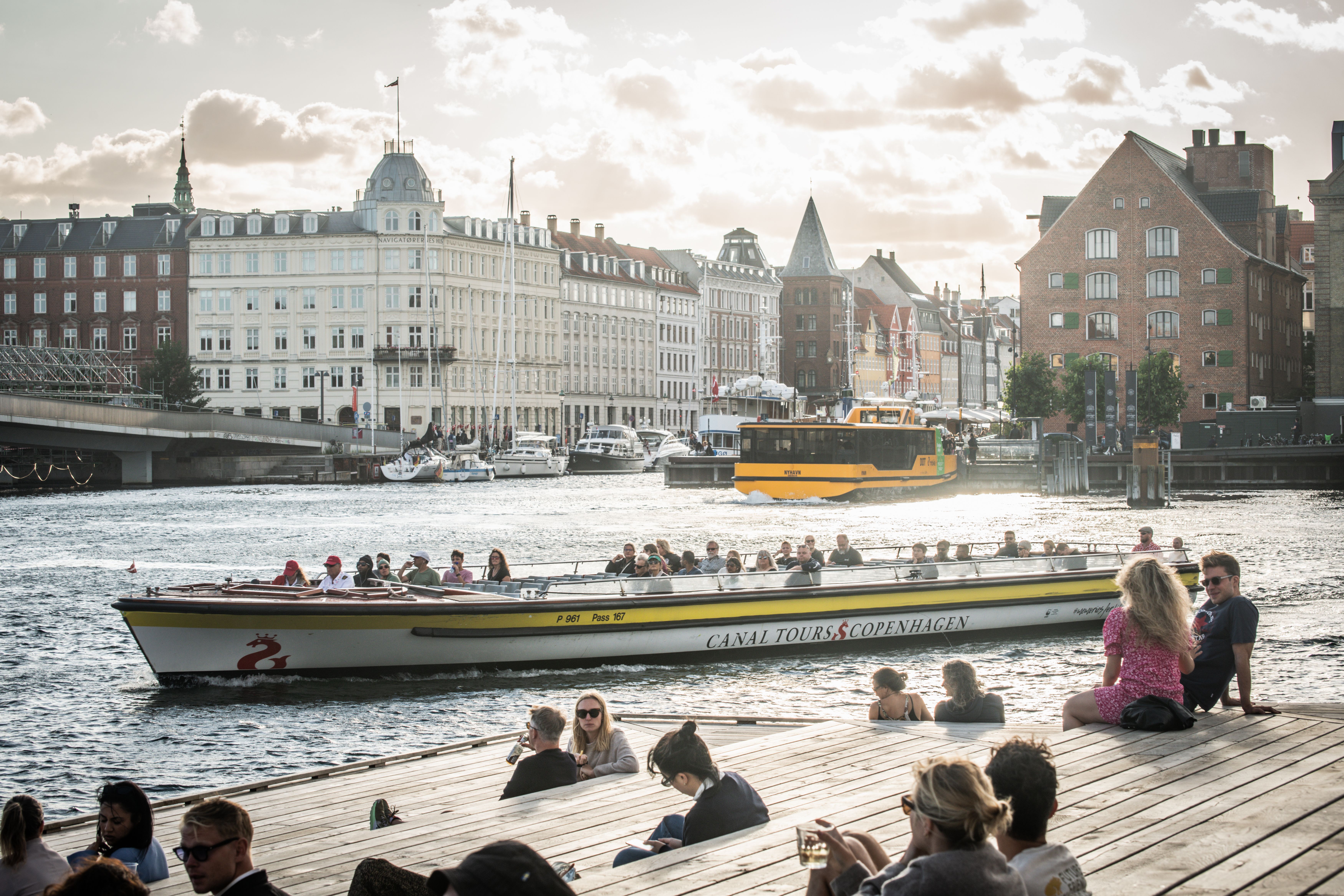People sitting on the dock watching a boat · Free Stock Photo