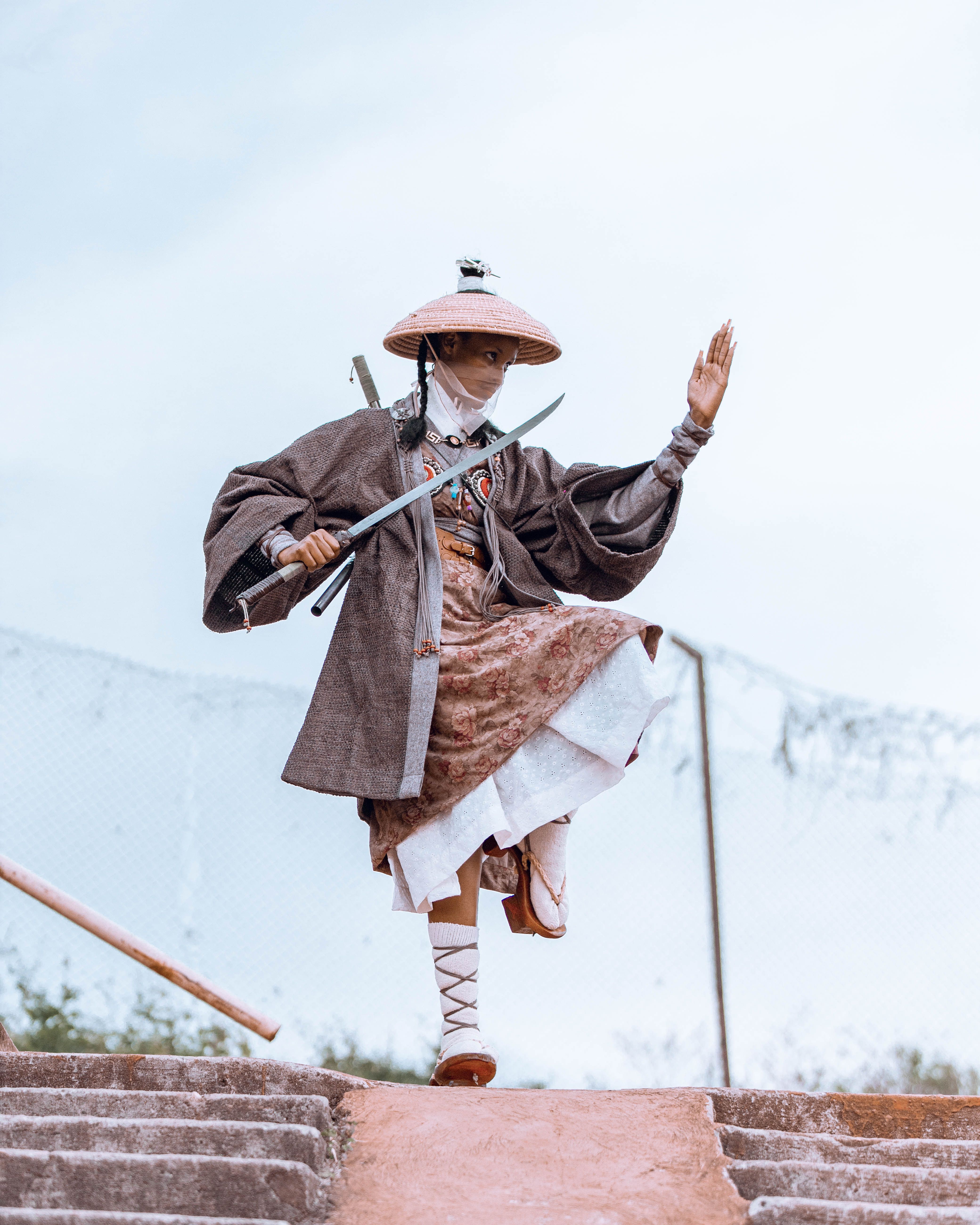 A man dressed in traditional clothing is holding a sword · Free Stock Photo