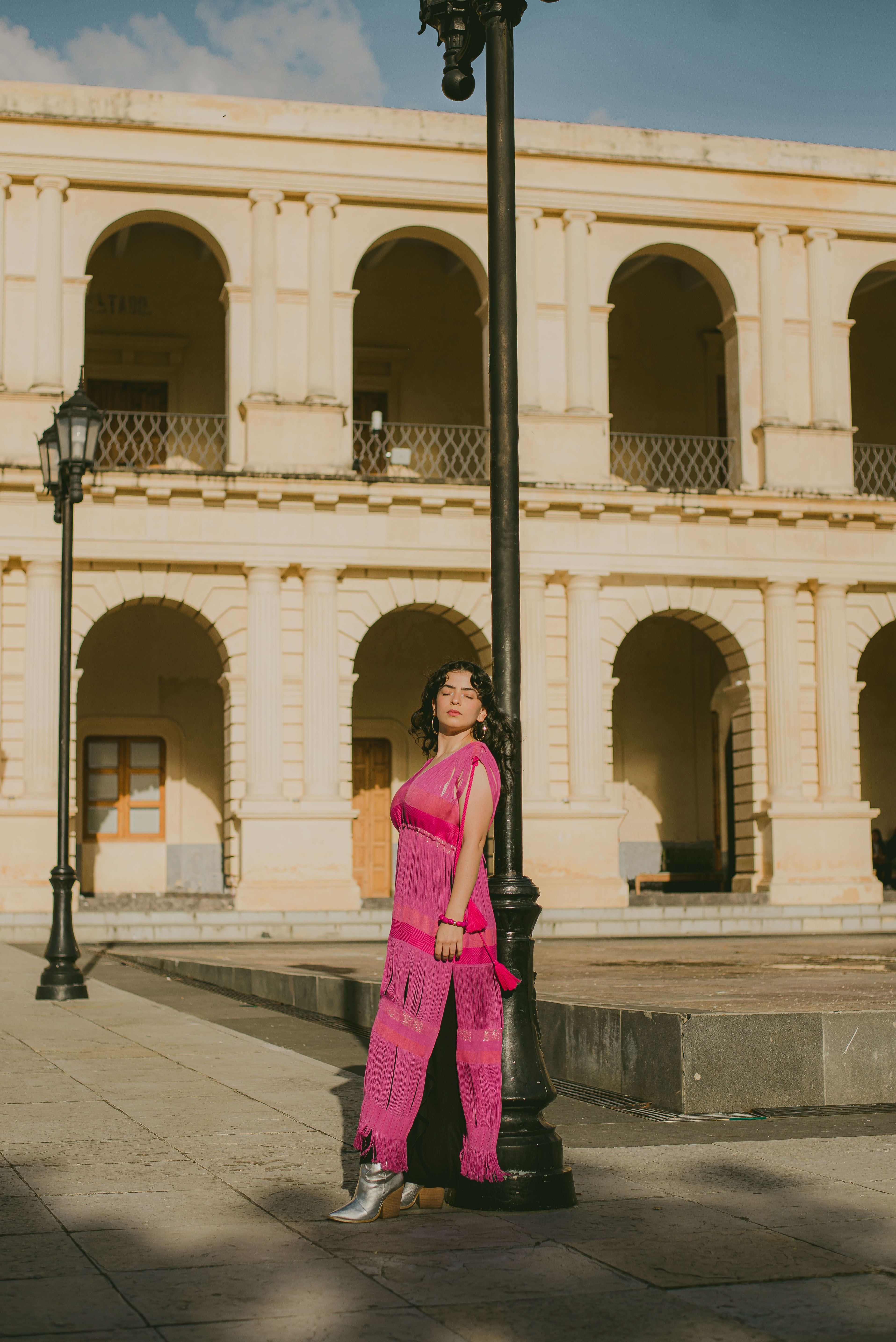 A woman in a pink dress posing in front of a lamp post · Free Stock Photo