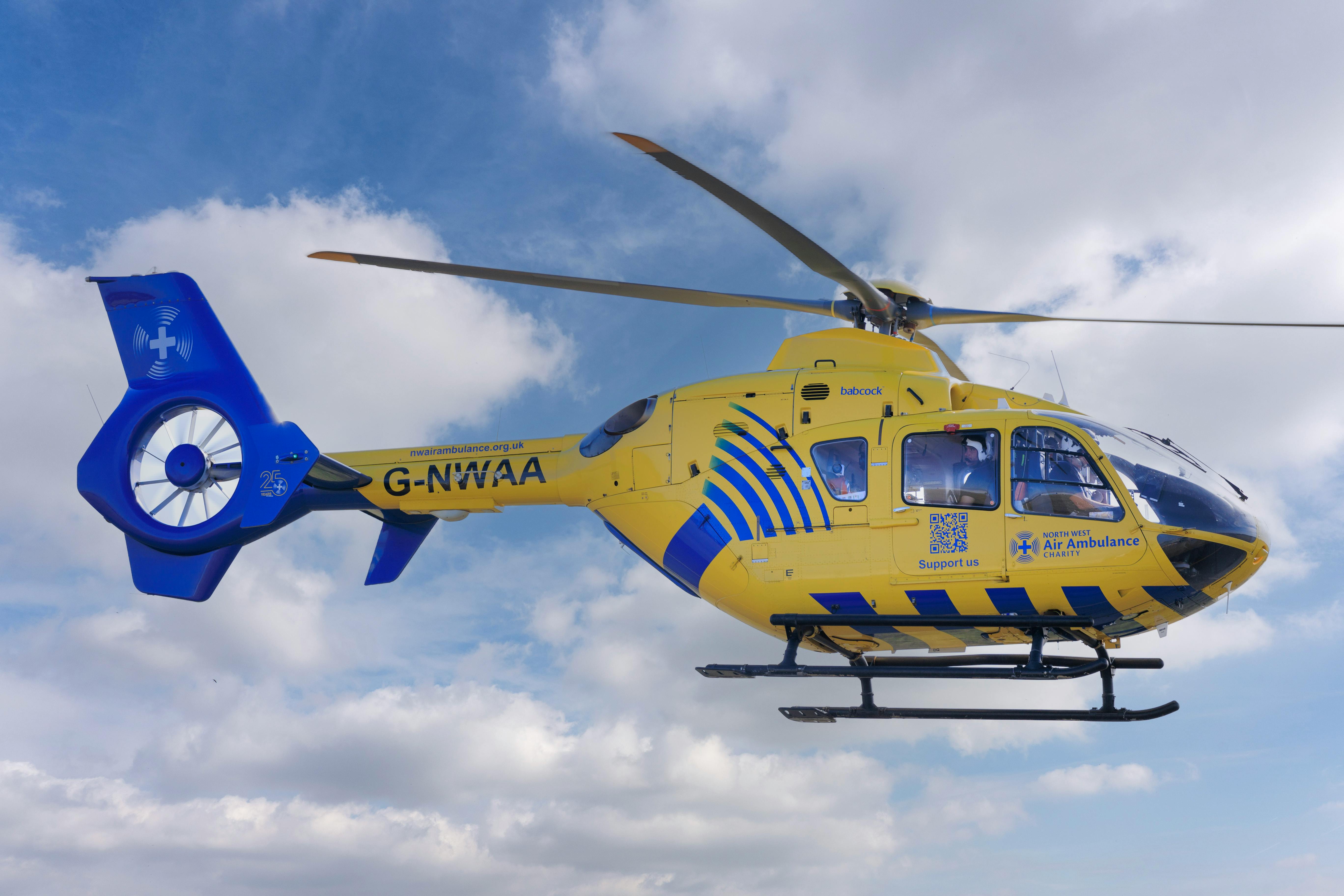 A yellow and blue helicopter flying in the sky · Free Stock Photo