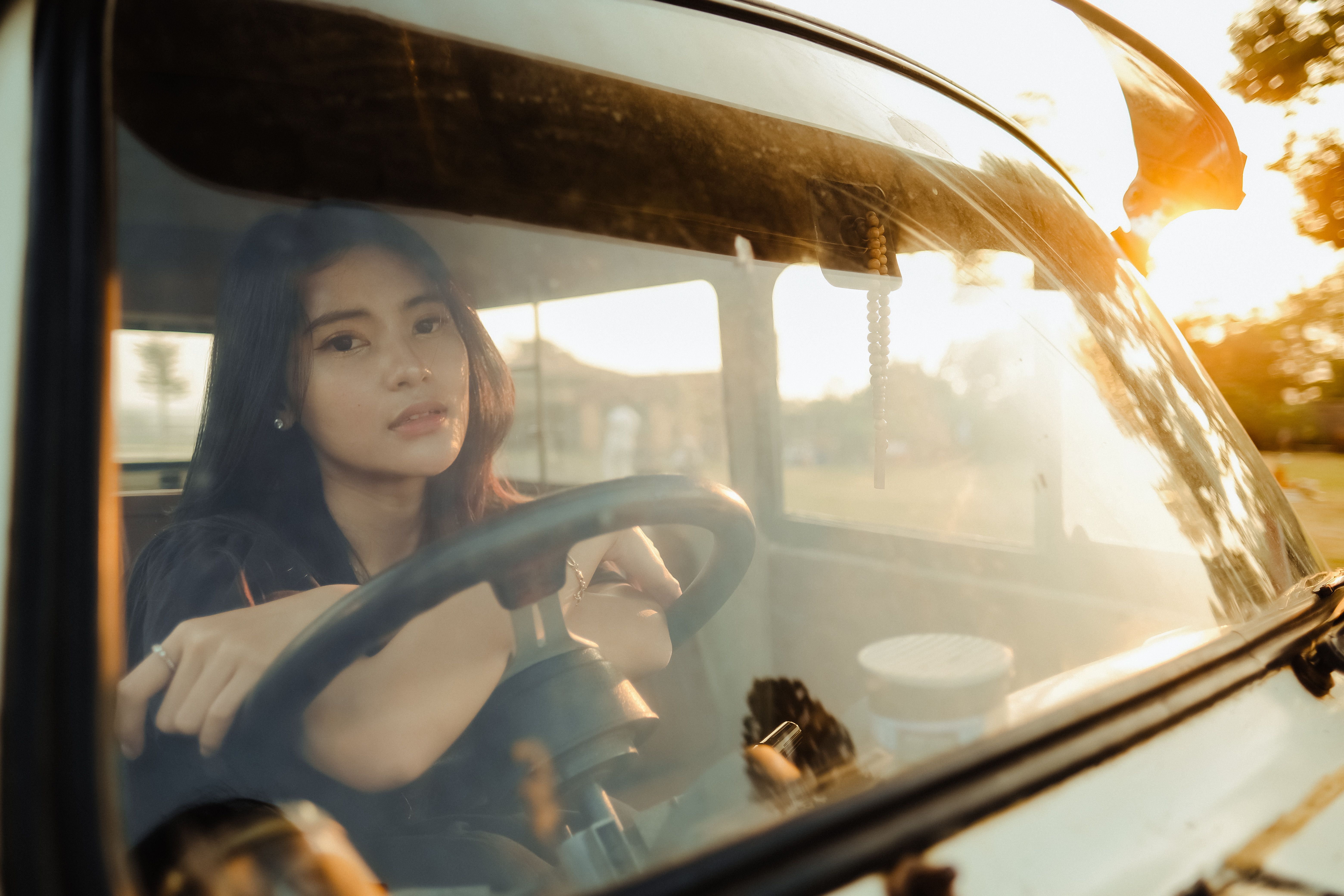 A woman driving a car at sunset · Free Stock Photo