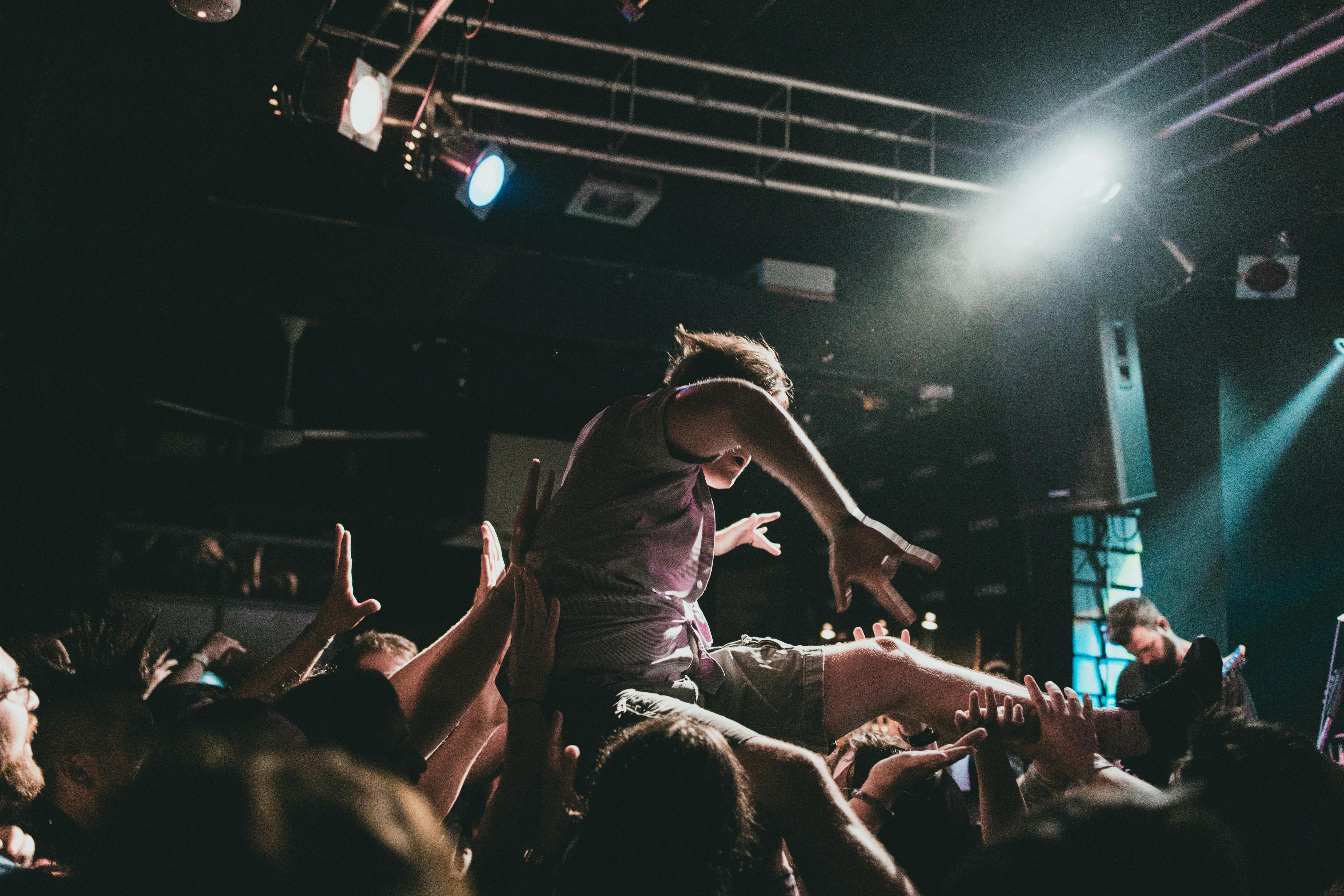 A man is on top of a crowd at a concert · Free Stock Photo