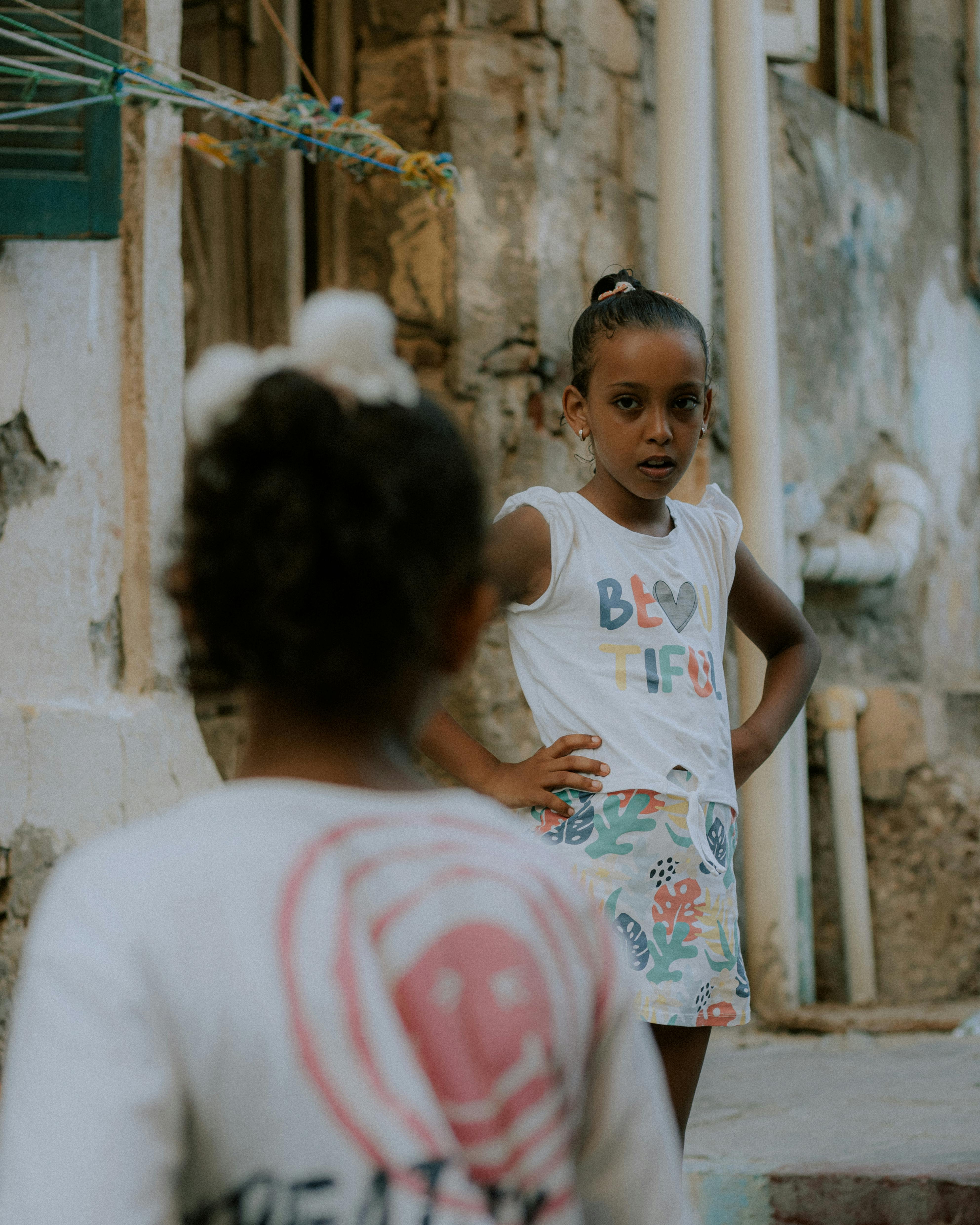 Two young girls standing in front of a building · Free Stock Photo