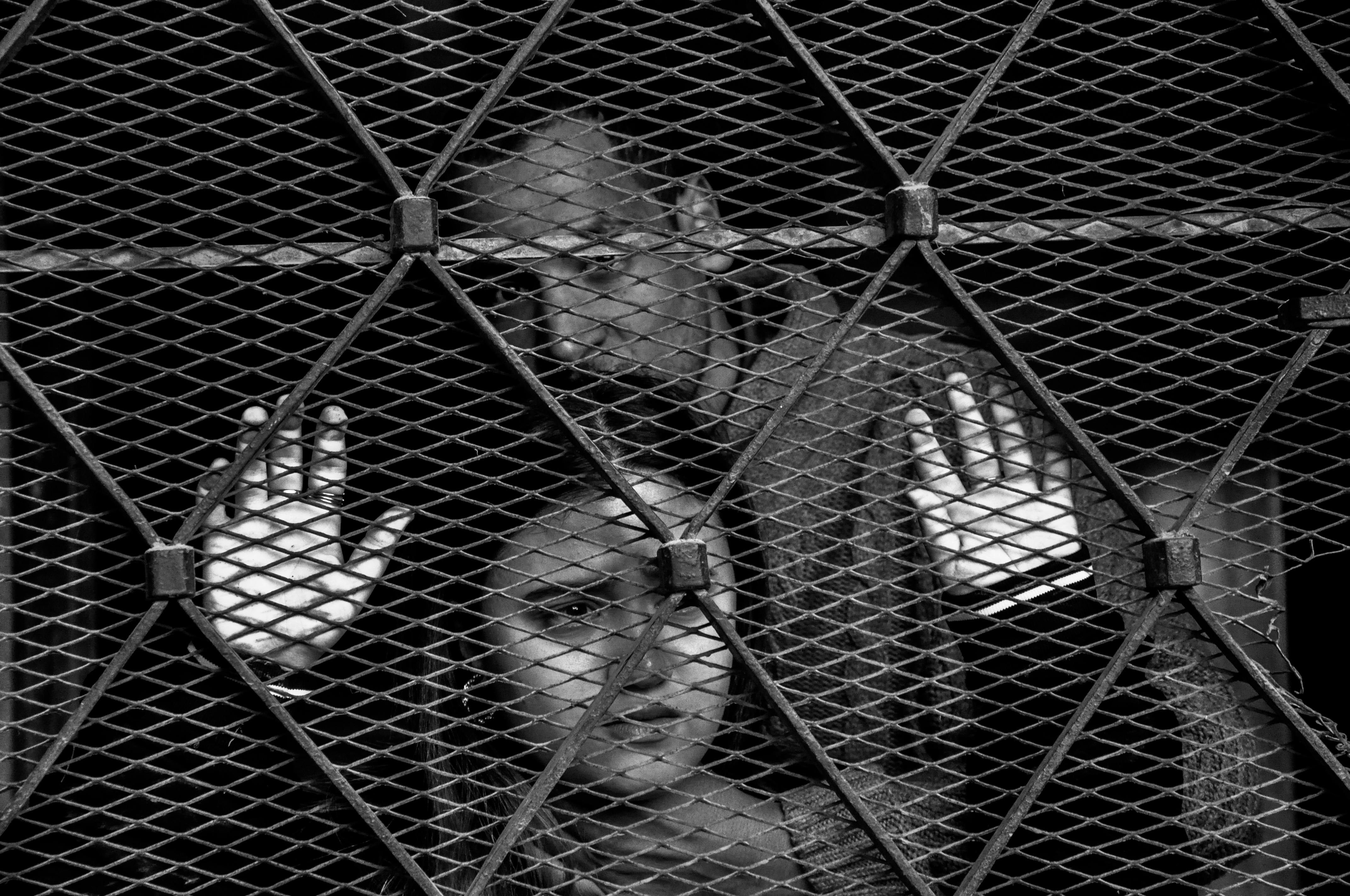 A man and woman behind bars in a cage · Free Stock Photo