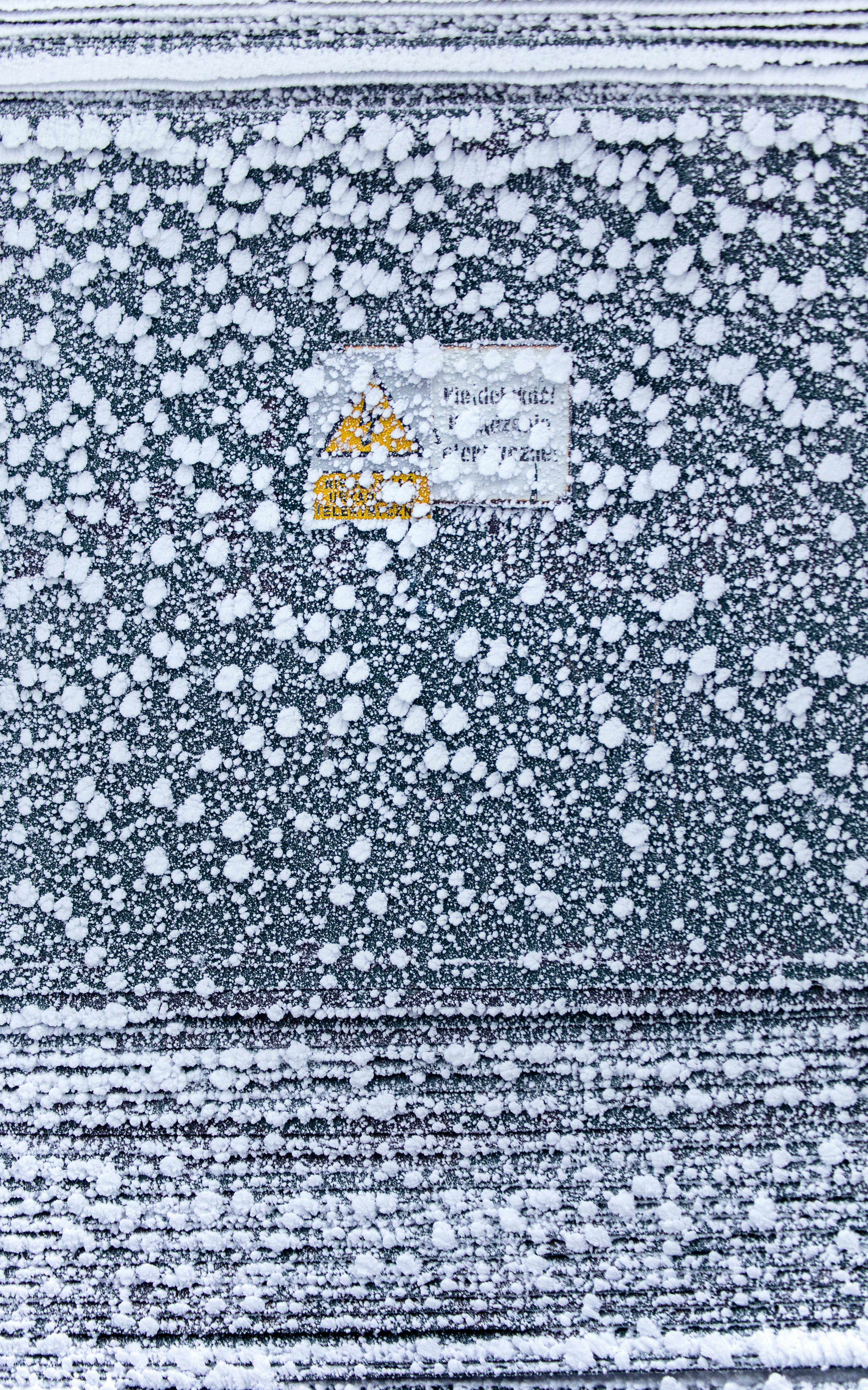A snow covered window with a yellow sticker on it · Free Stock Photo