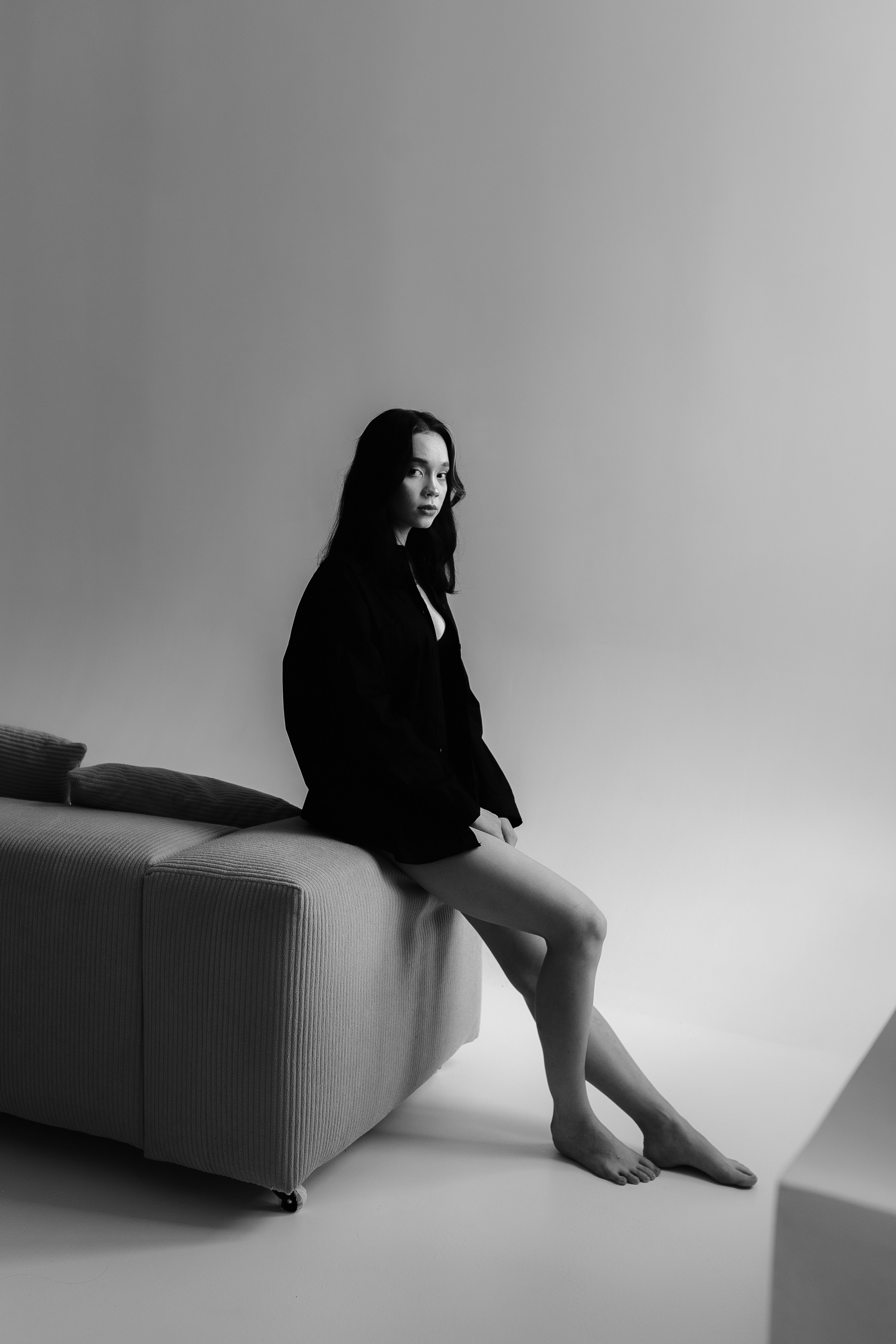 A woman sitting on a couch in black and white · Free Stock Photo