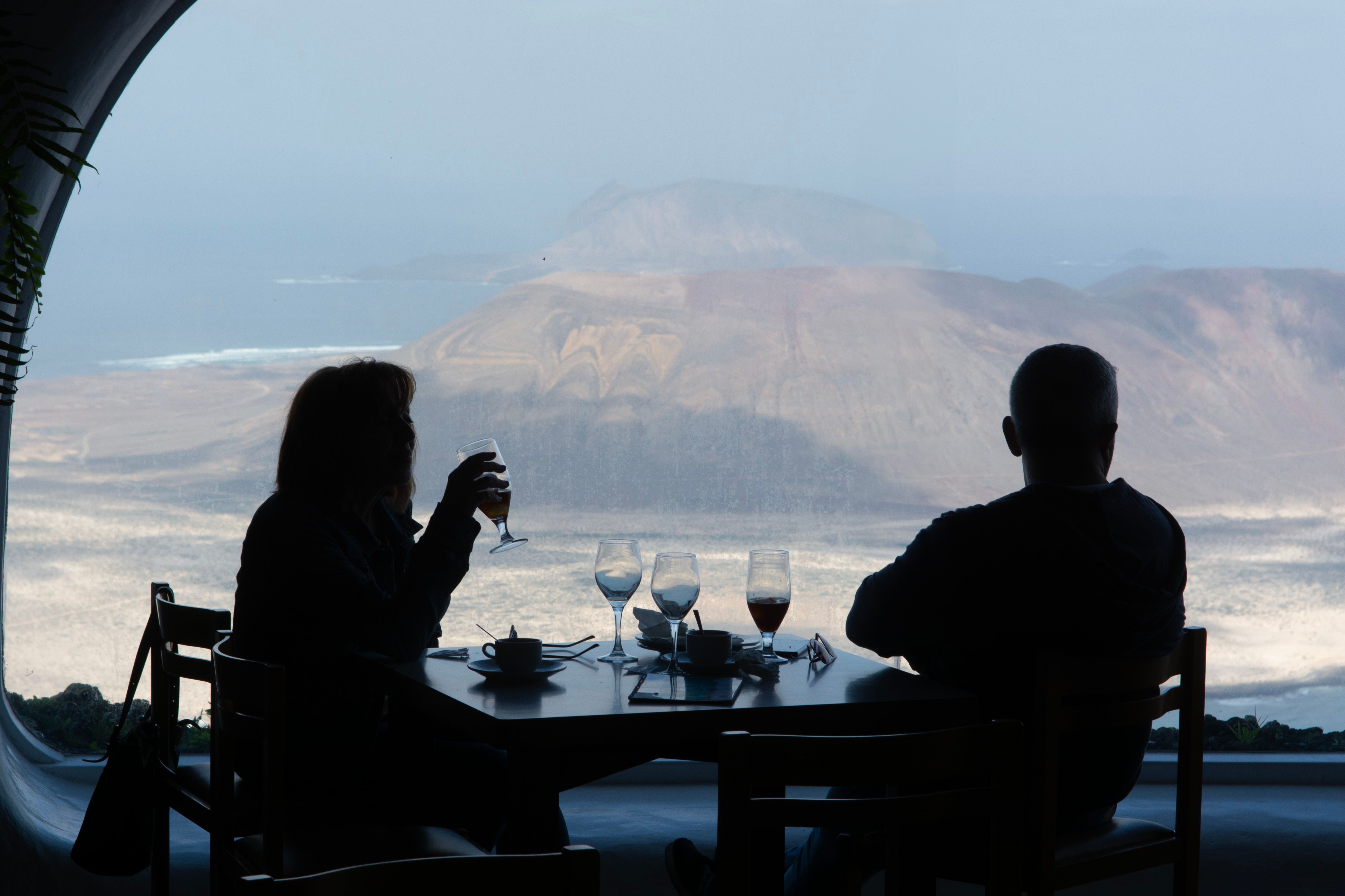 Two people sitting at a table in front of a window overlooking the ...