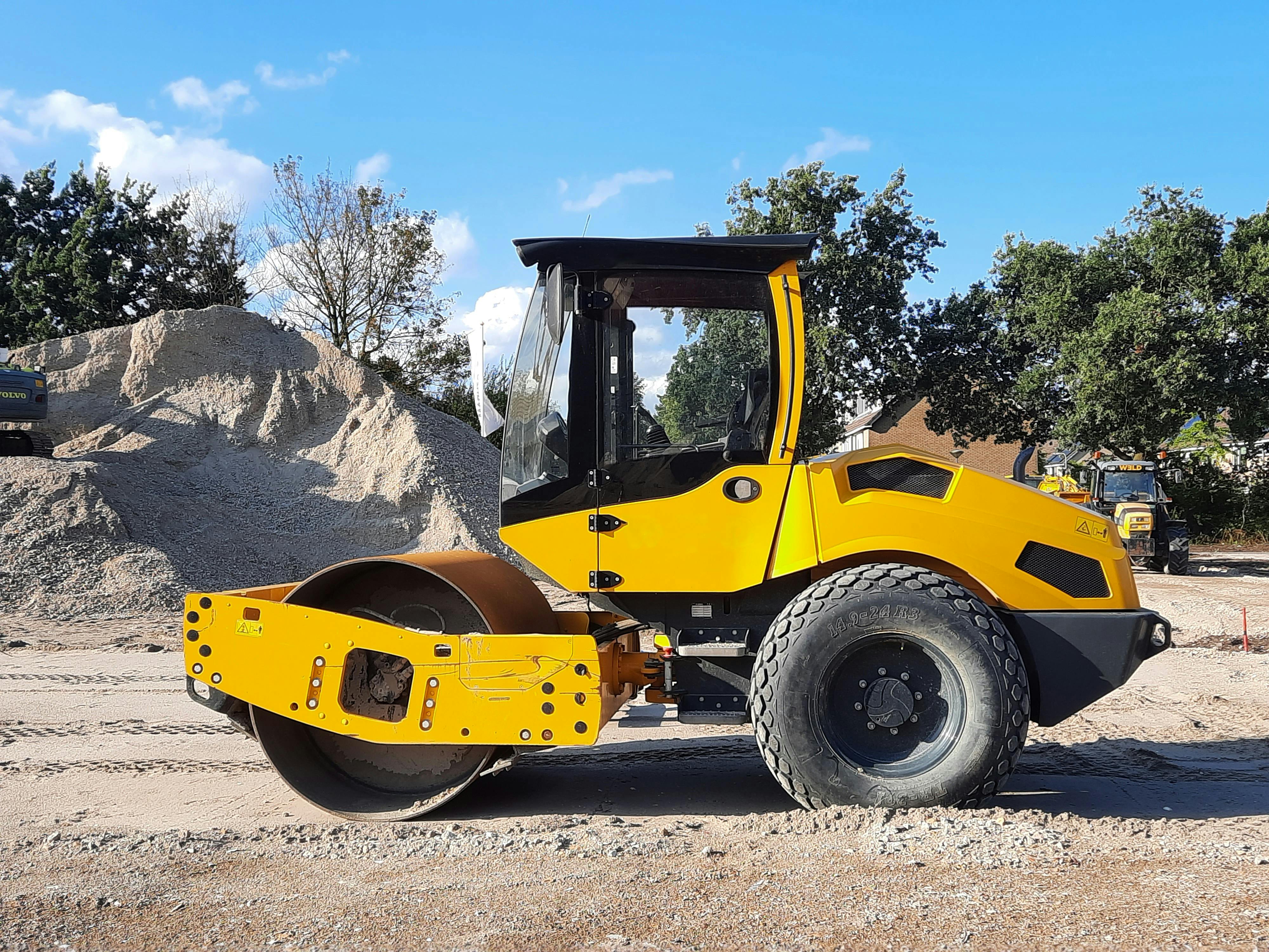A yellow road roller sitting on top of dirt · Free Stock Photo