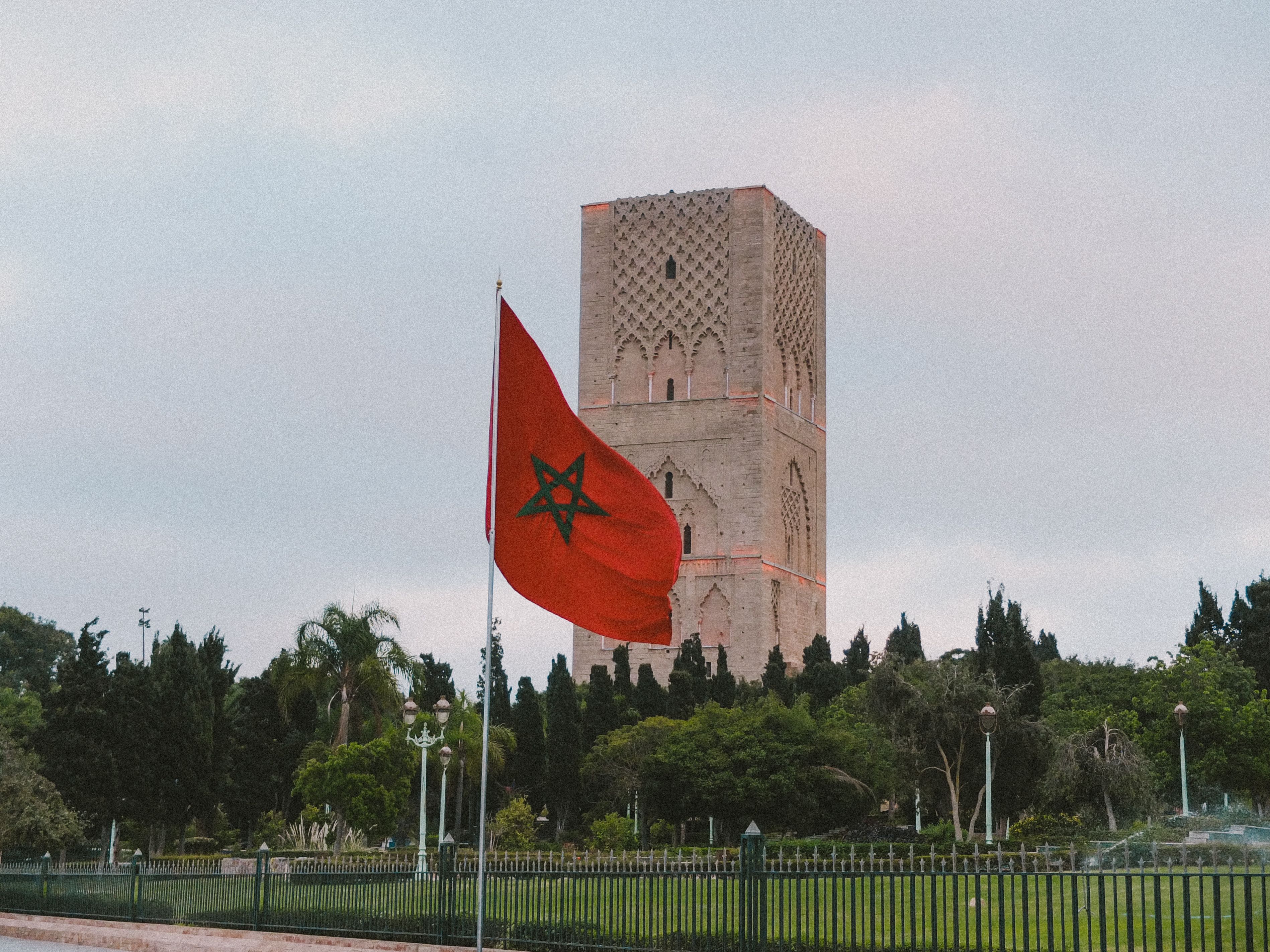 A red flag flying over a tower in morocco · Free Stock Photo