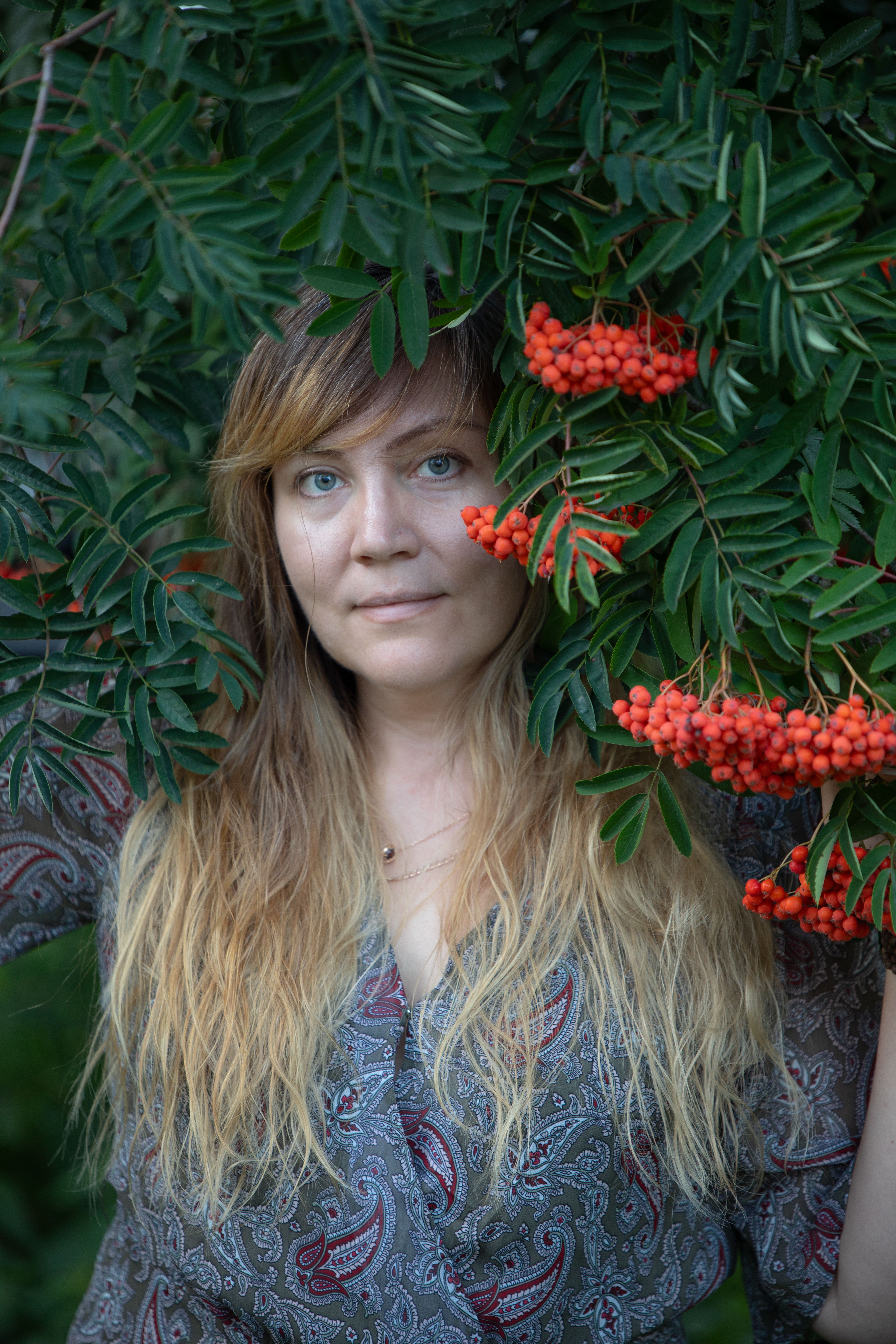 A woman with long hair and a bunch of red berries · Free Stock Photo