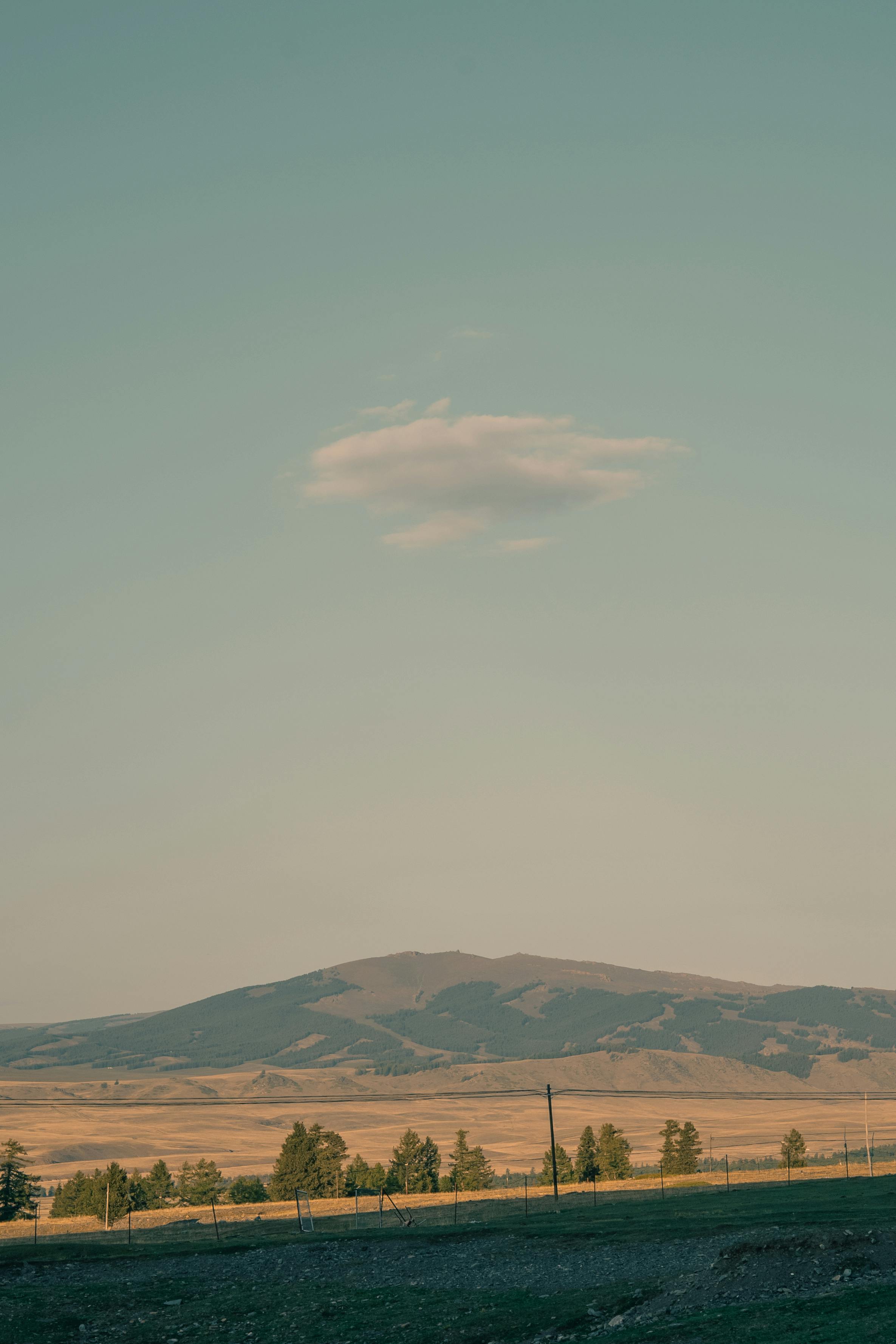 A lone cloud in the sky over a field · Free Stock Photo