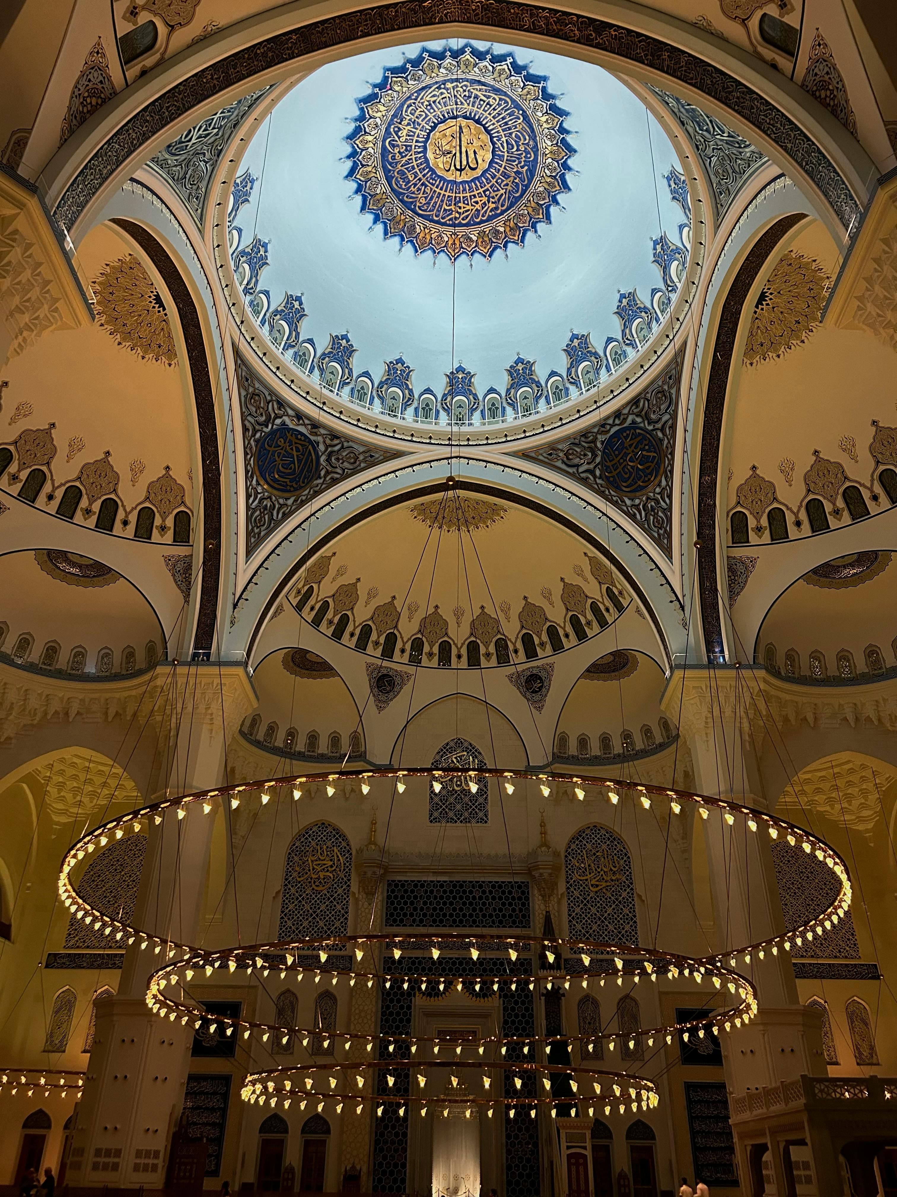 The dome of a mosque with a circular light fixture · Free Stock Photo
