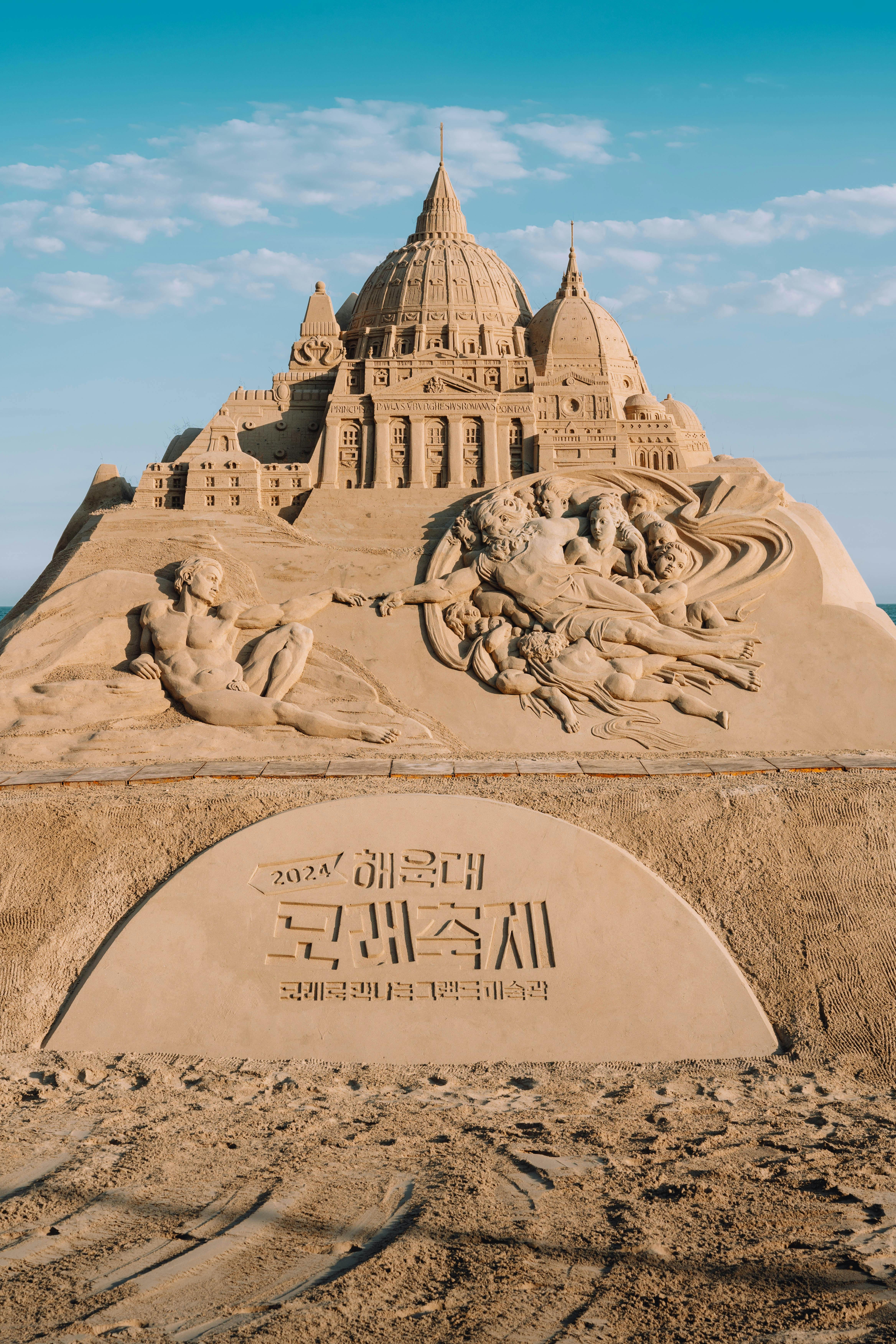 A sand sculpture of a castle on a beach · Free Stock Photo