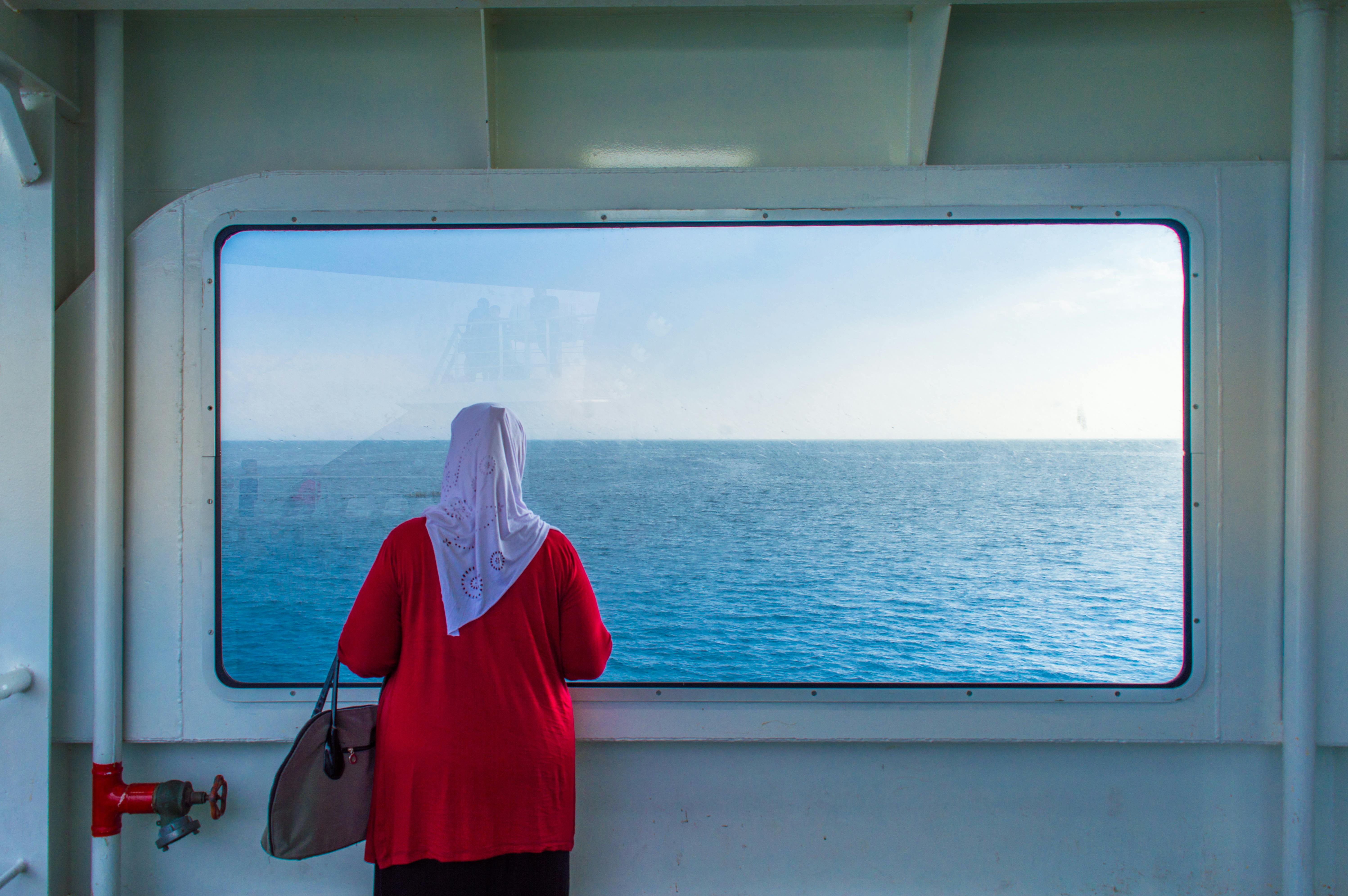 Woman Travelling on a Cruise Ship Looking out the Window at the View of ...
