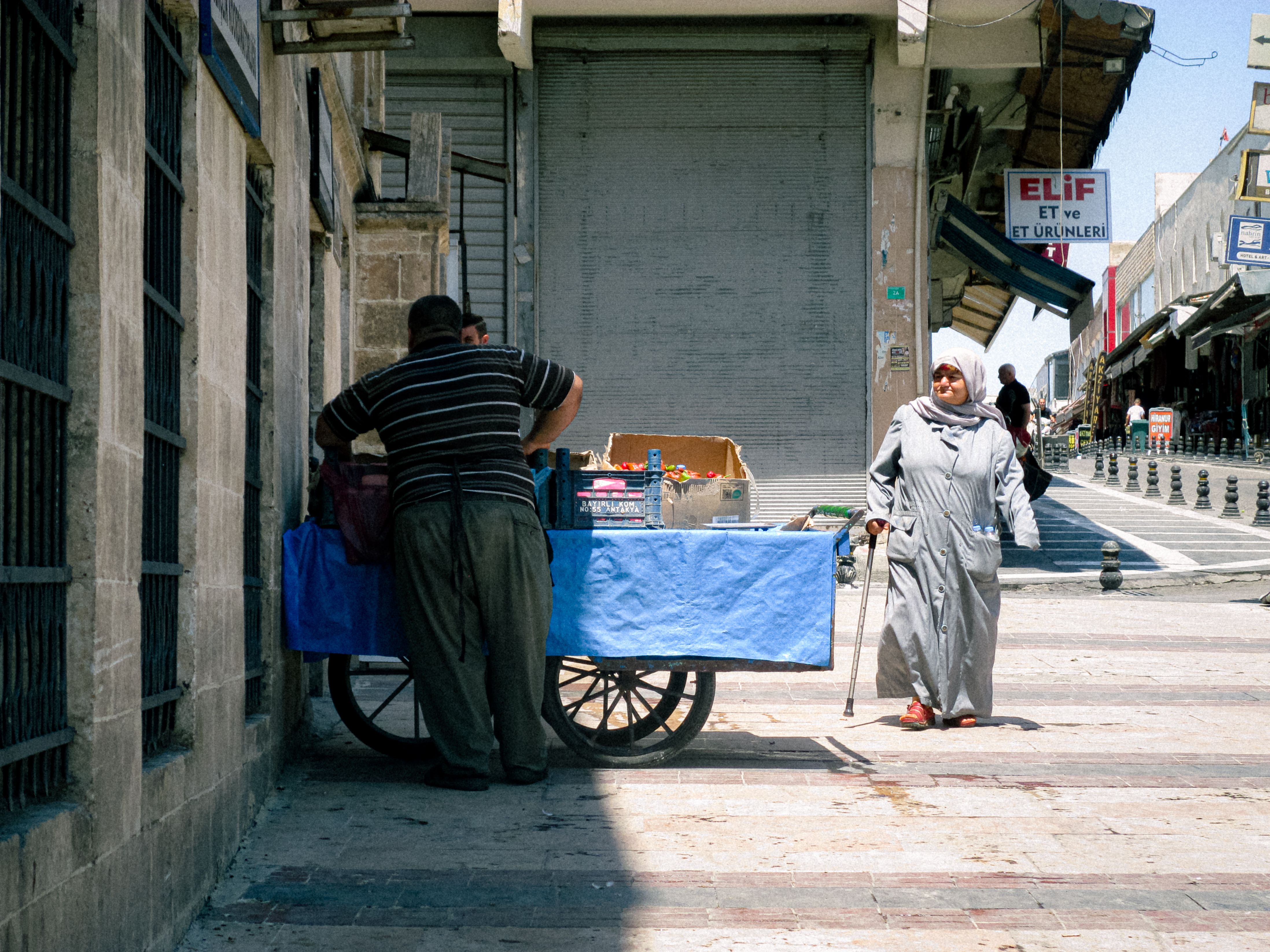 A man pushing a cart down a street with a woman walking beside him ...