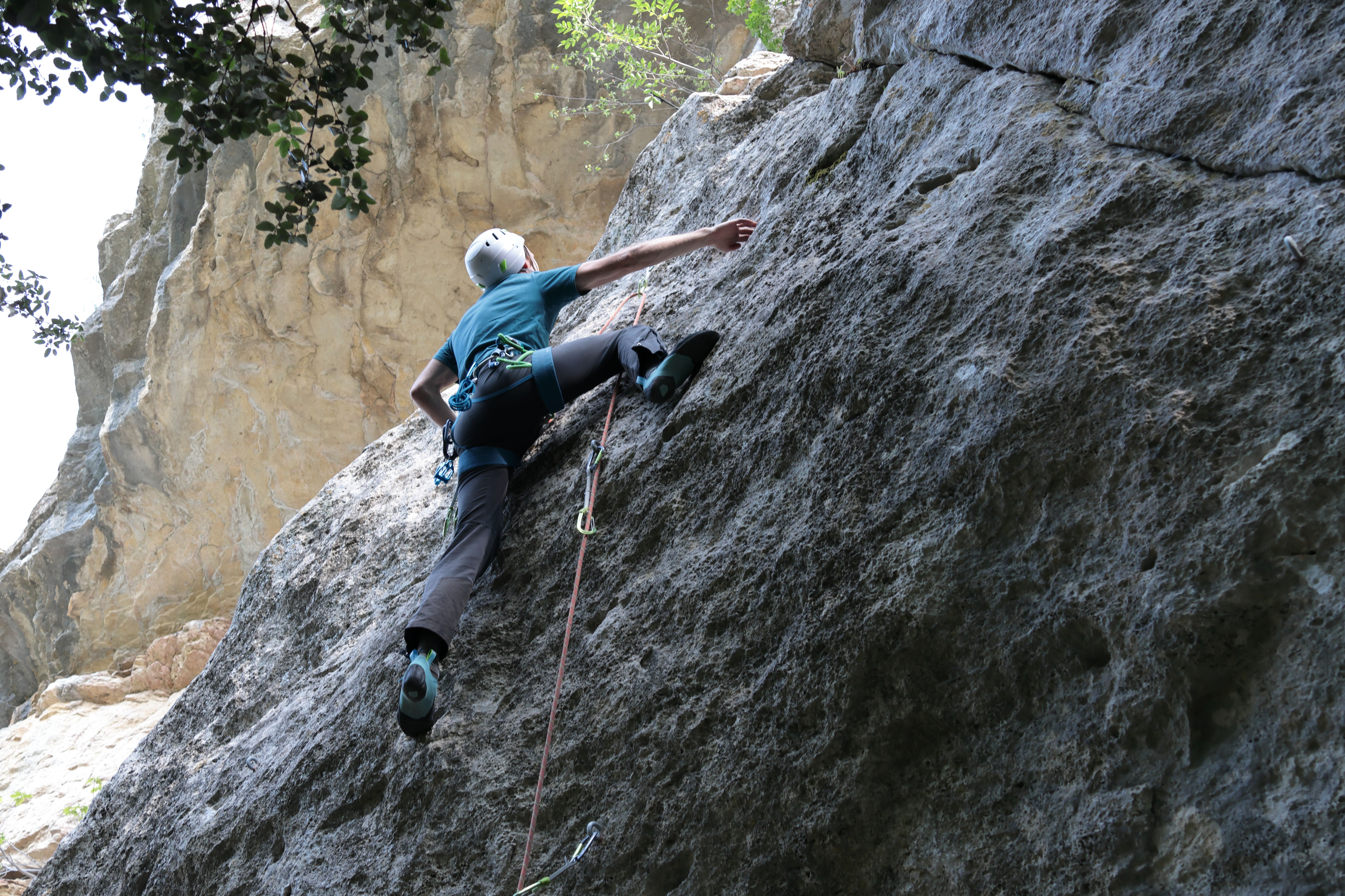 A person climbing up a rock face · Free Stock Photo