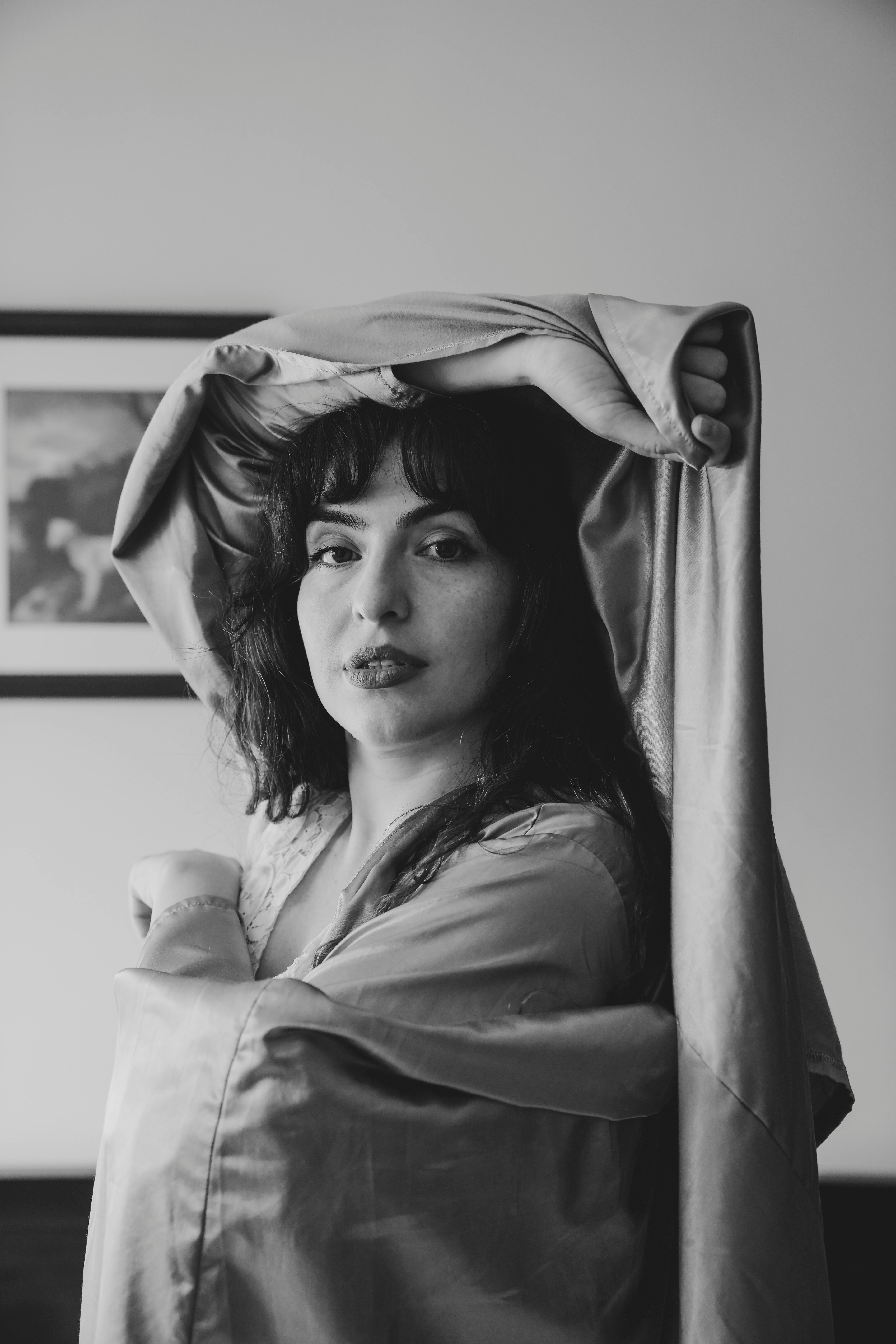 A woman is holding a sheet over her head · Free Stock Photo