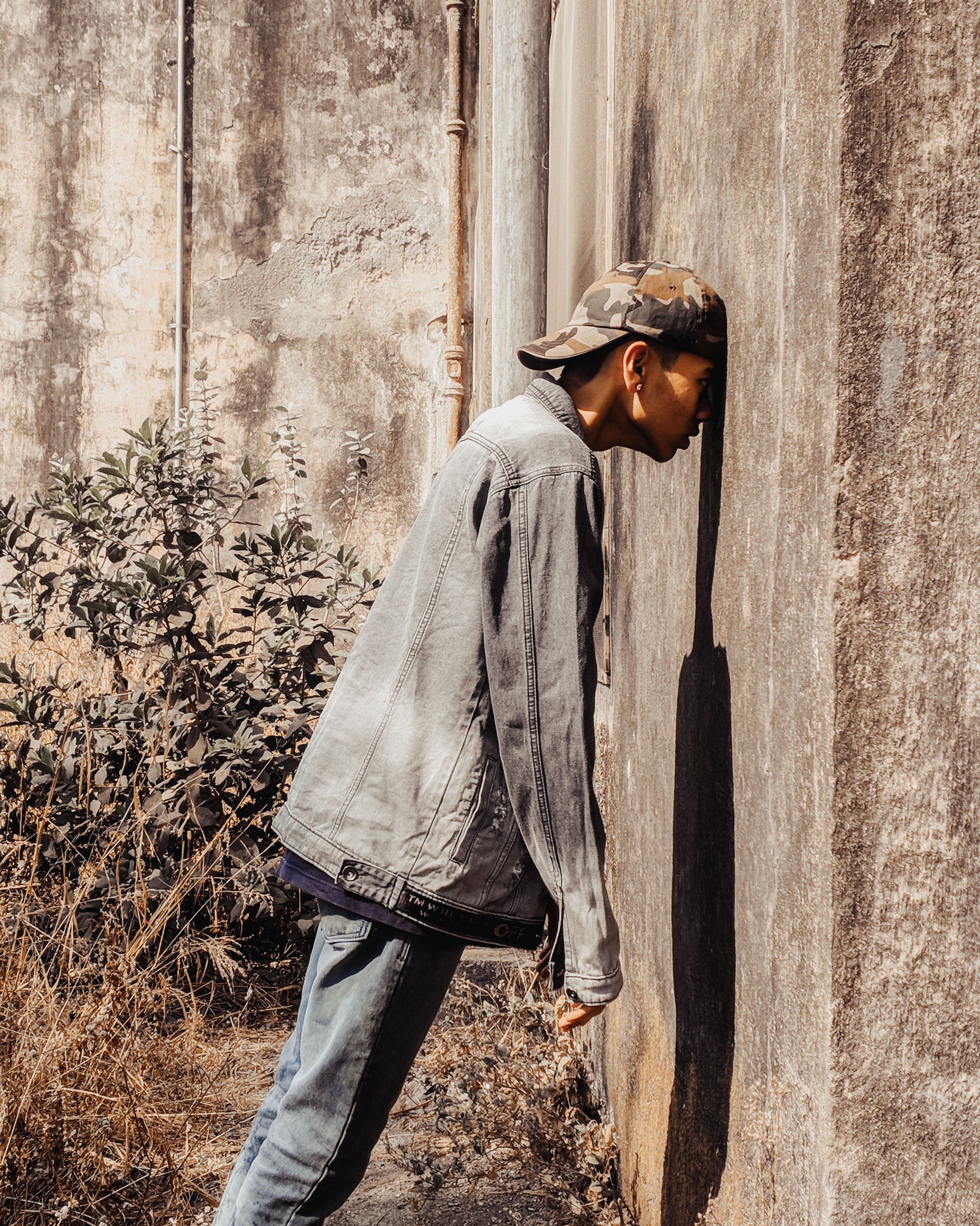 Man in Brown Coat Standing Beside Concrete Wall · Free Stock Photo