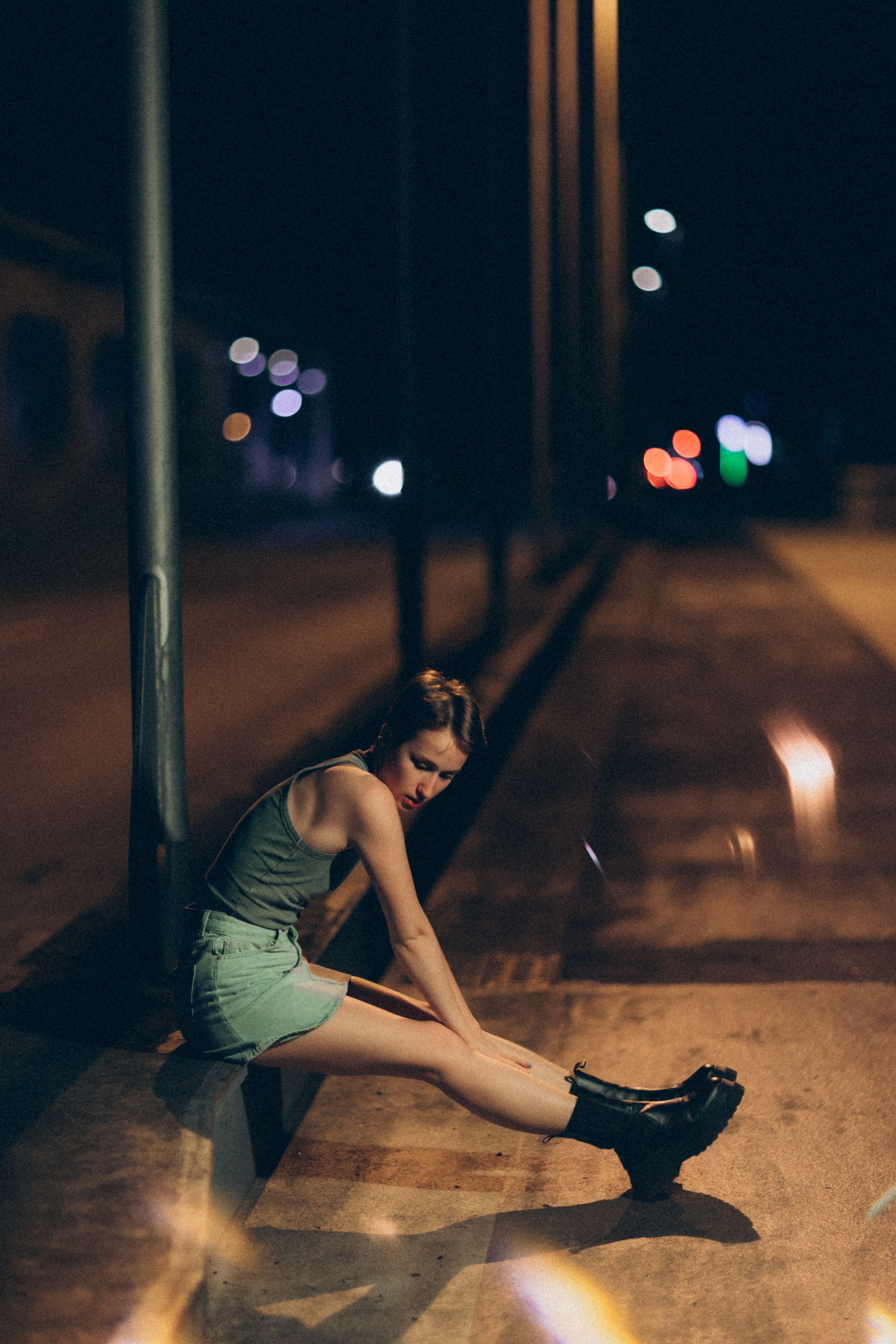 A woman sitting on the ground at night · Free Stock Photo