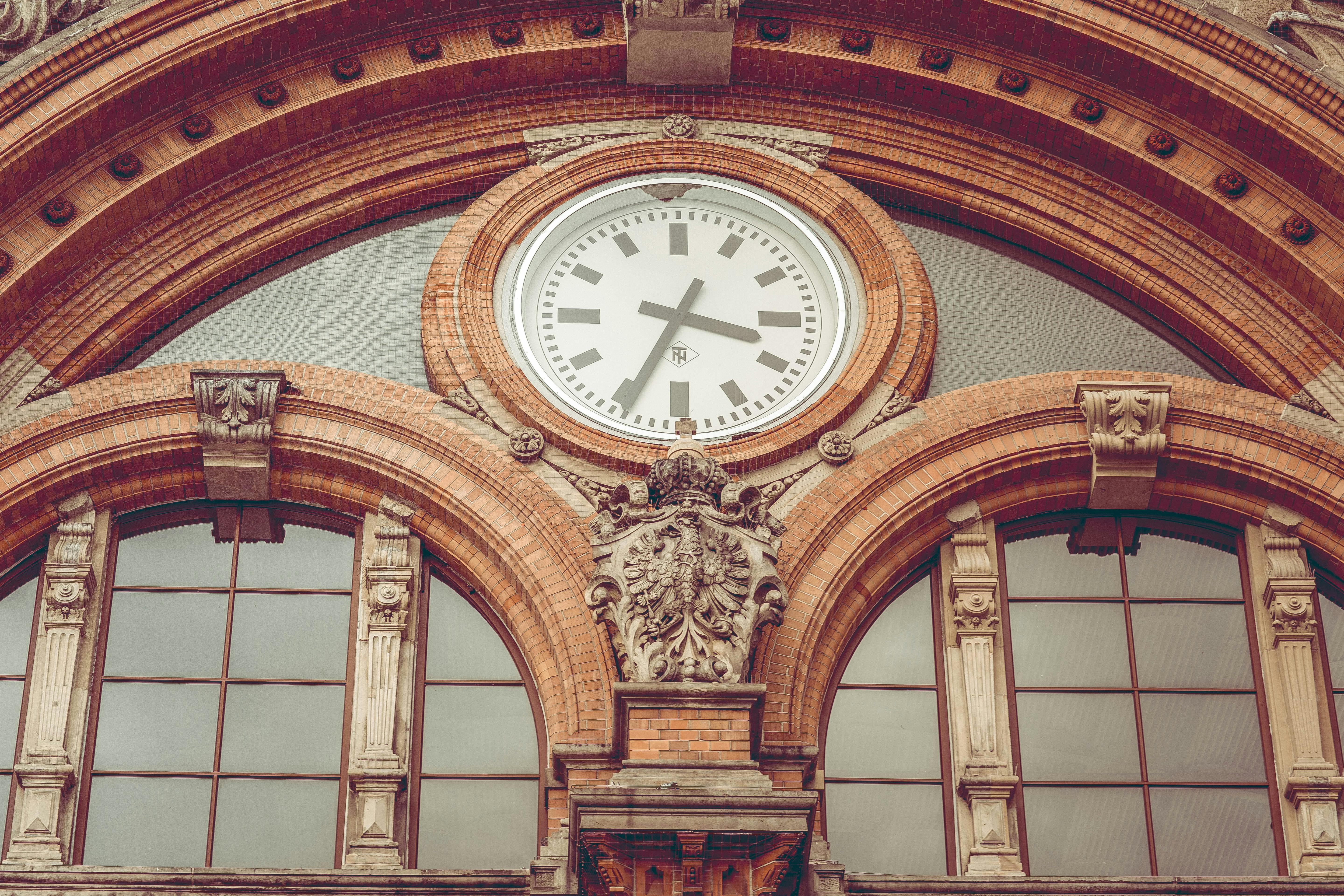 Brown Concrete Hall With Clock · Free Stock Photo