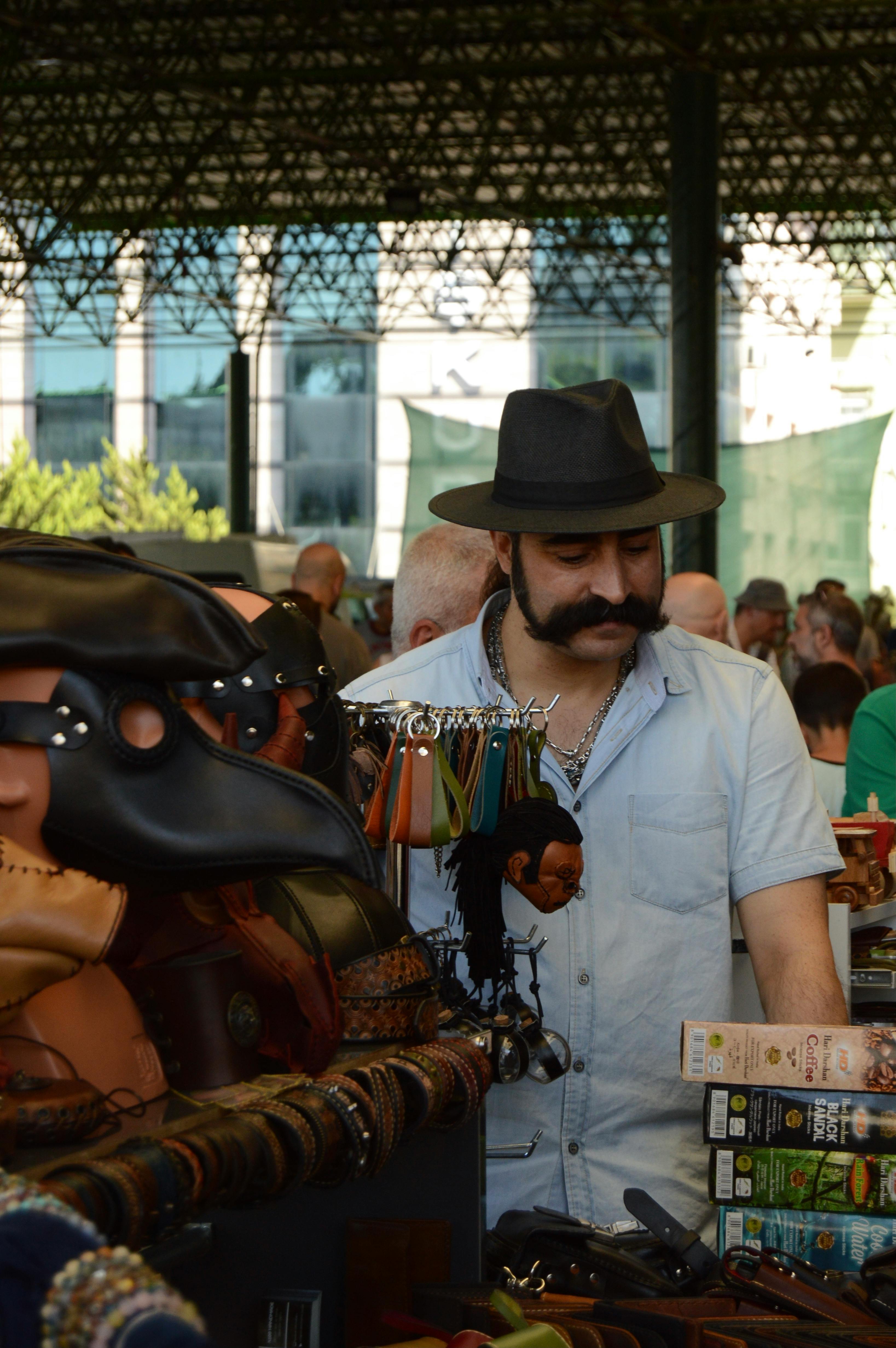A man with a hat and mustache at a market · Free Stock Photo